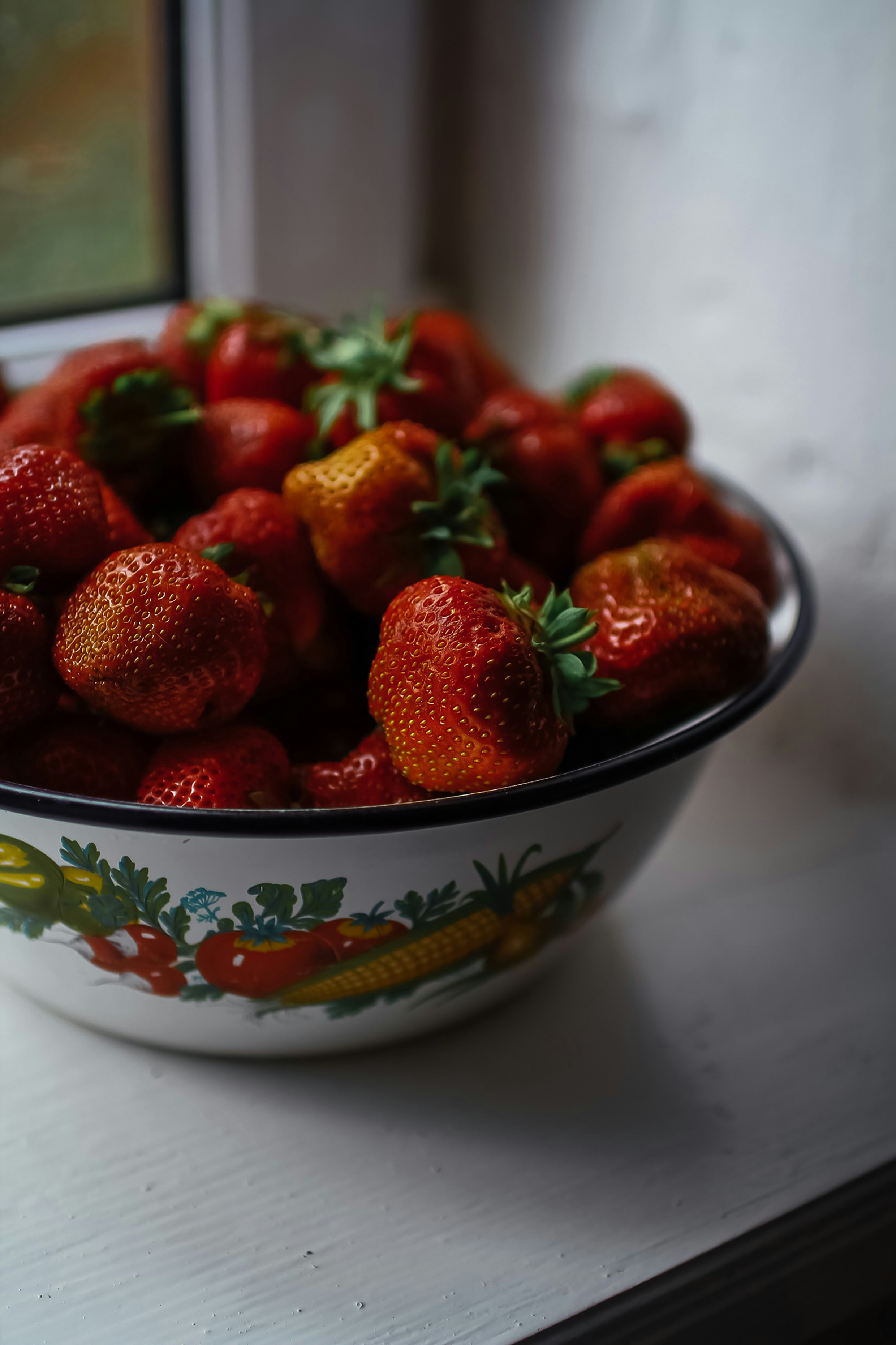 Sunlit Strawberries in a Painted Ceramic Bowl by the Windowsill