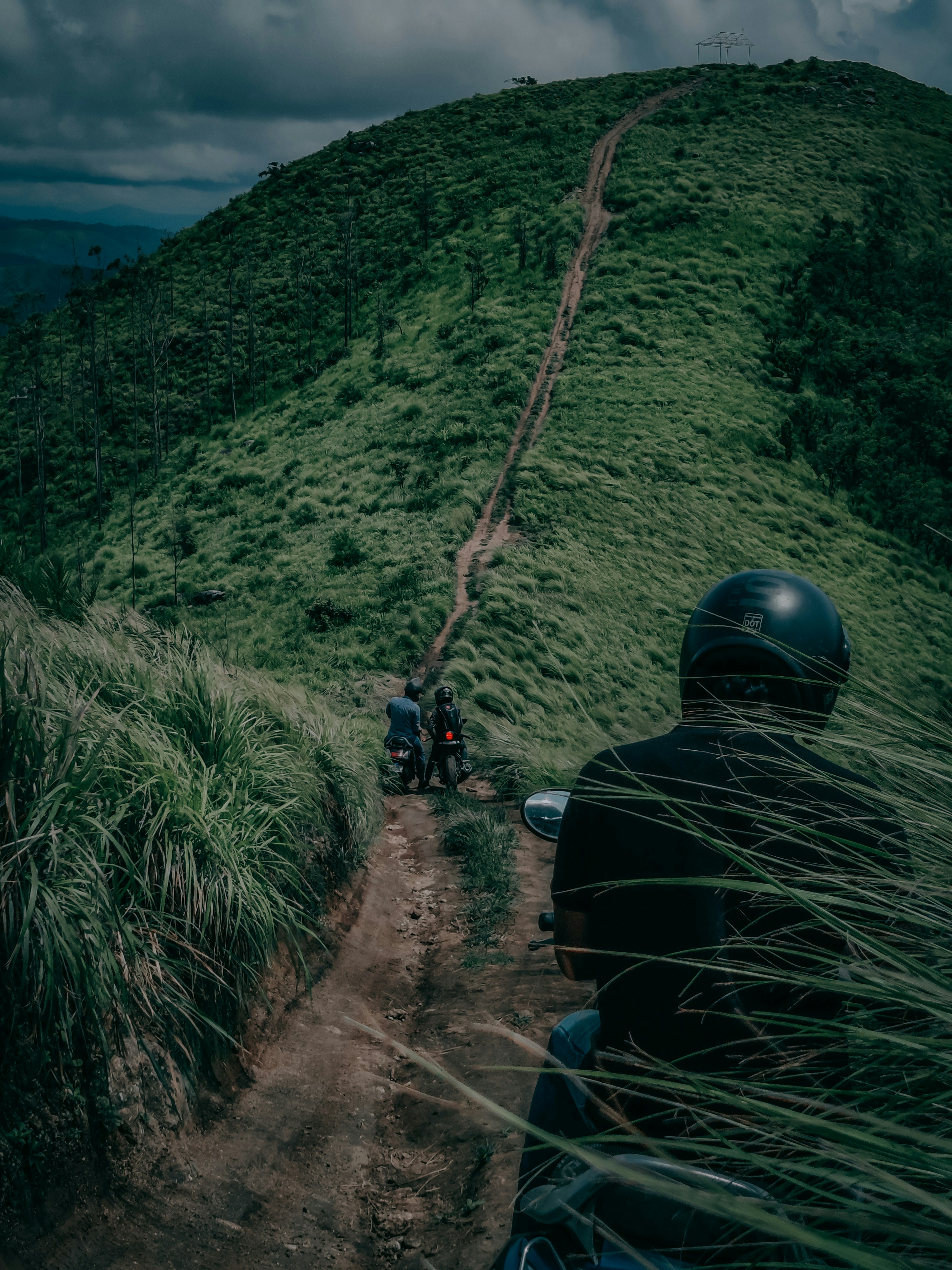 Ridgebound Ascent: Two Riders Thread a Narrow Dirt Path Through Verdant Slopes