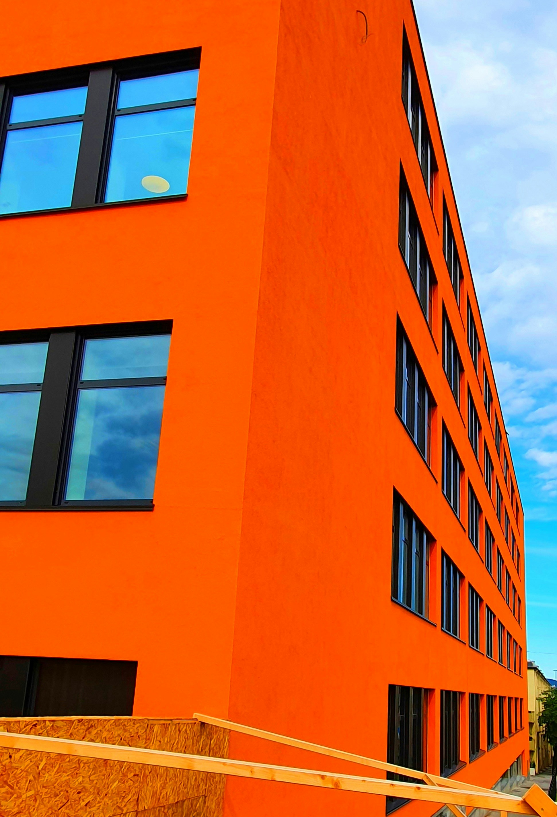 Bold Orange Facade: A Slanted Perspective of a Modern Building