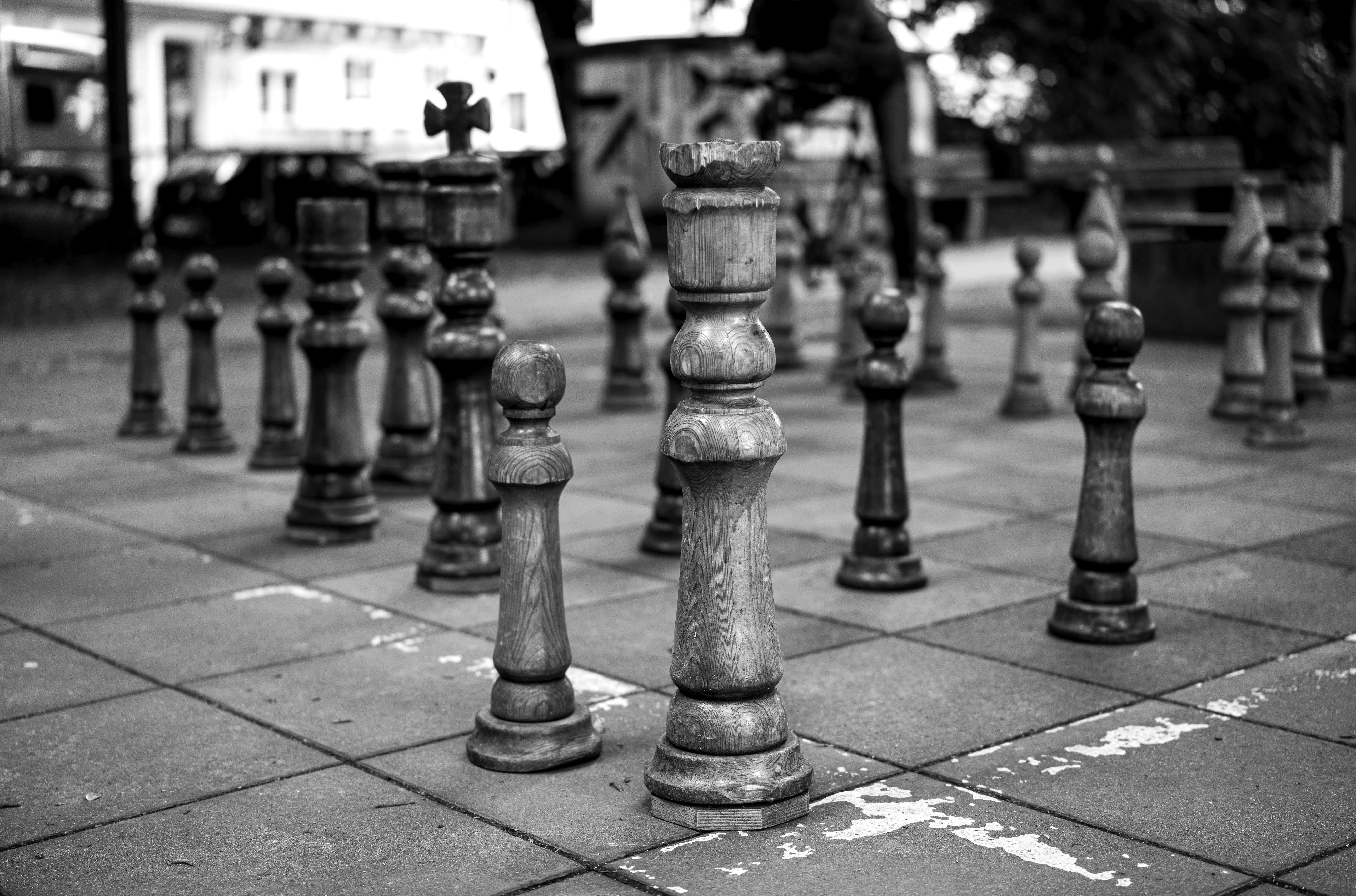 Sentinels on a Mono Plaza: Weathered Chess Pieces on a Quiet Grid