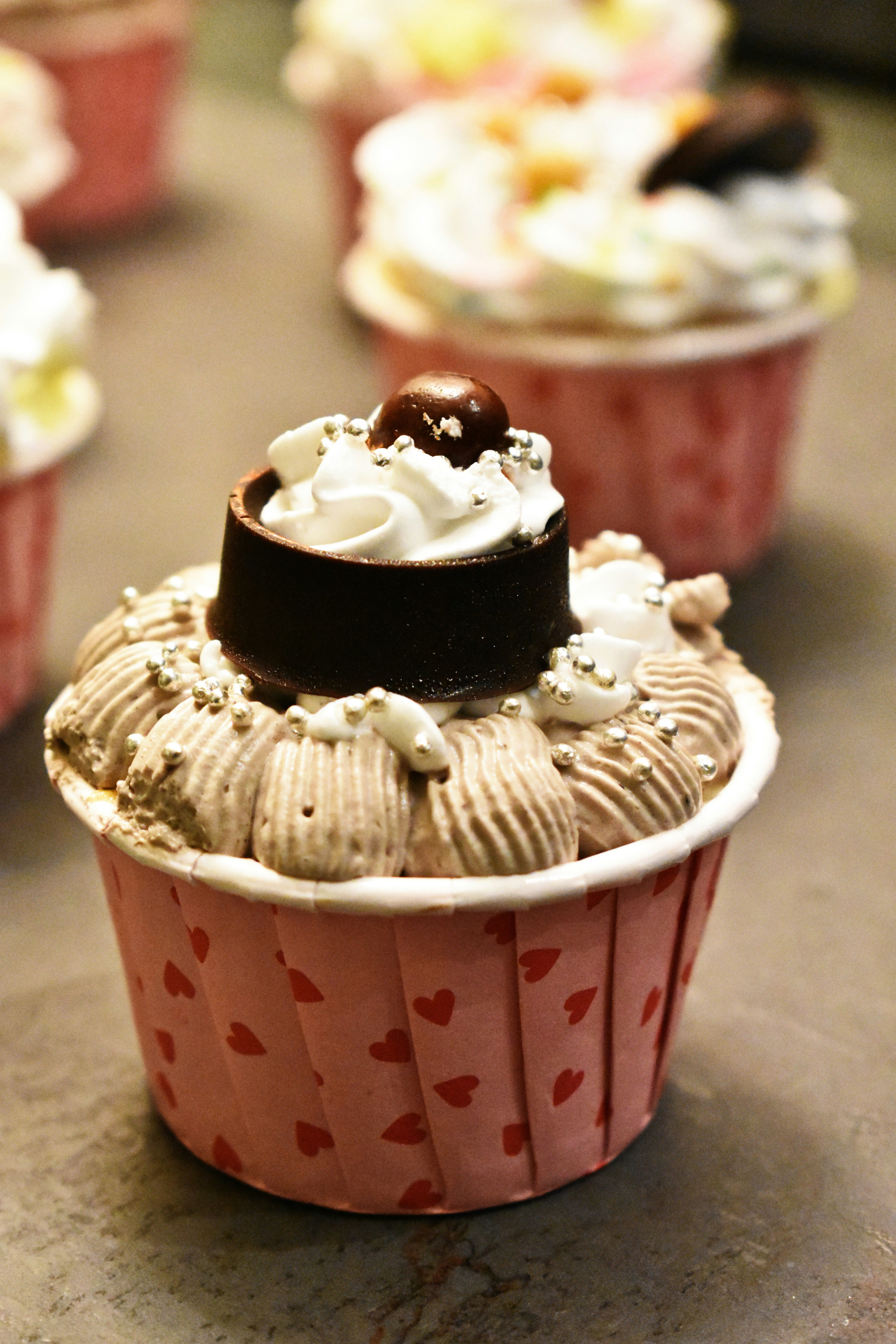 Cocoa Crown Cupcake: A Chocolate Disk and Pearl Frosting on a Heart-Wrapped Delight