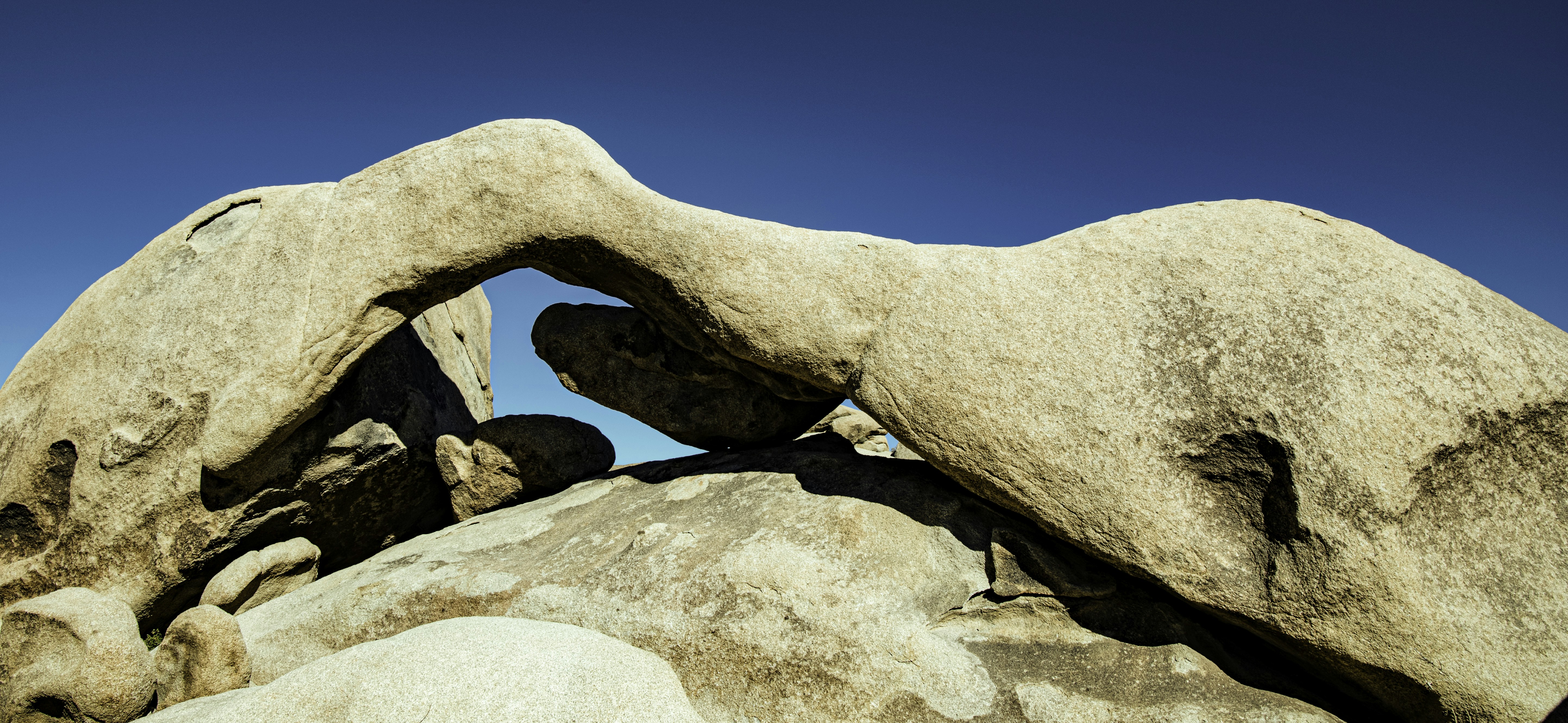 The Granite Arch: Weathered Bridge Against a Pristine Sky