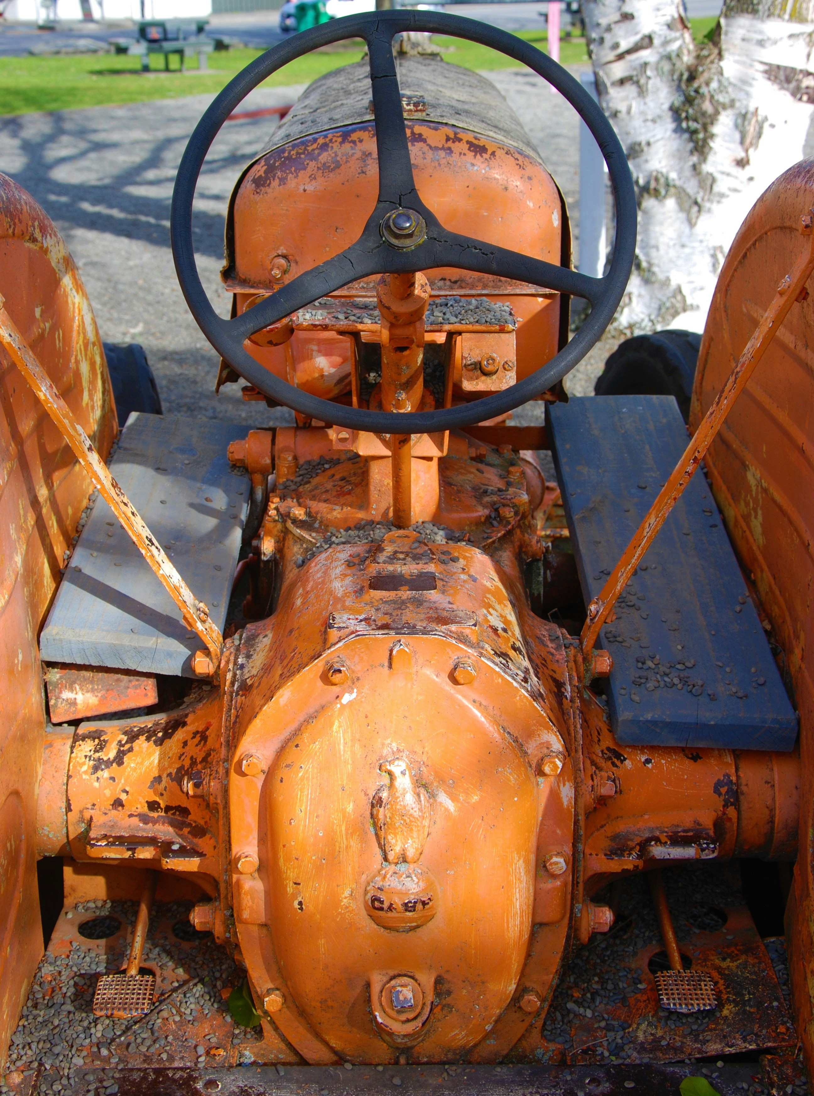 Orange Rust and a Three-Bar Wheel: Front View of a Weathered Vintage Tractor