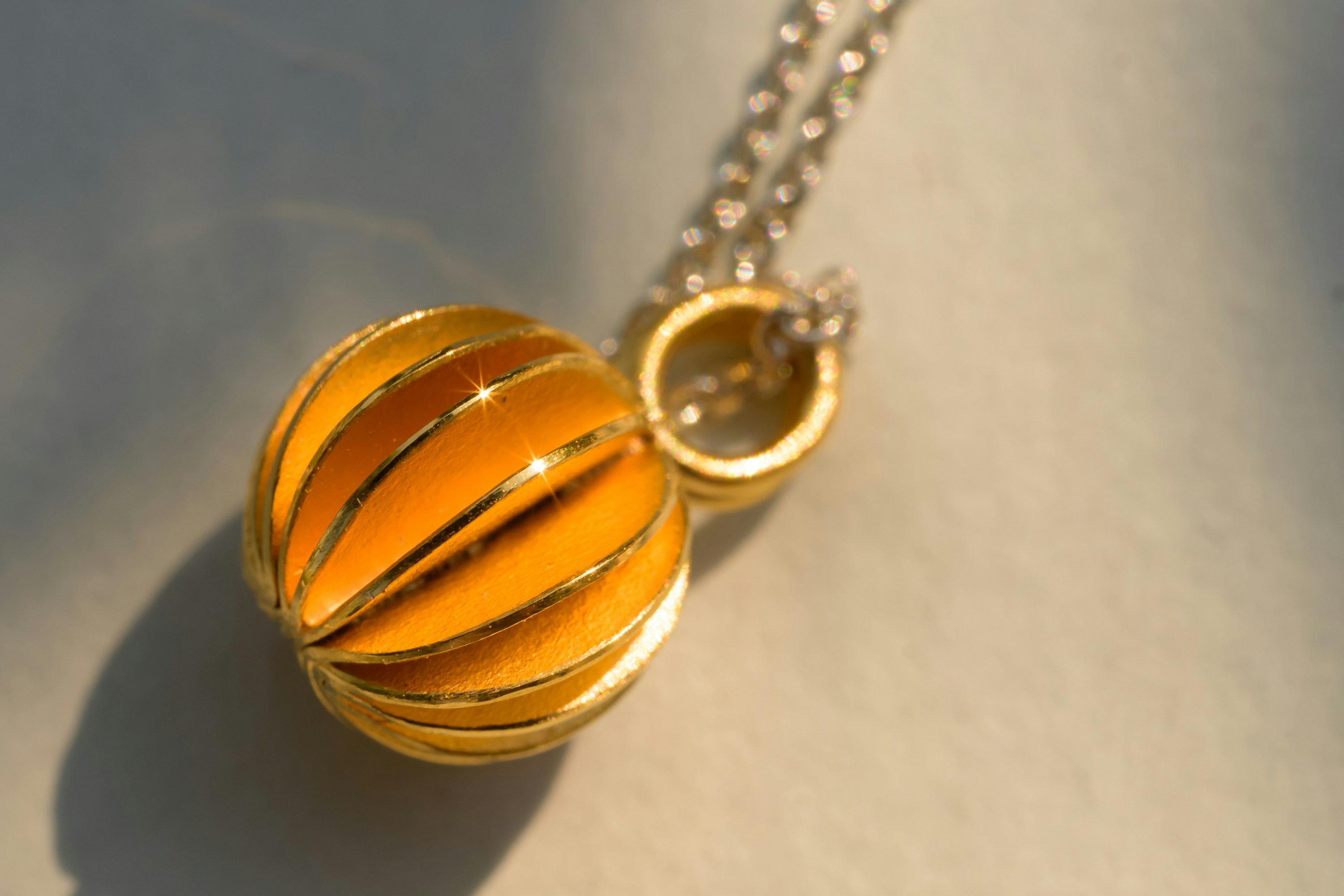 Gilded Orb on a Silver Chain: a Macro Portrait of a Striped Pendant