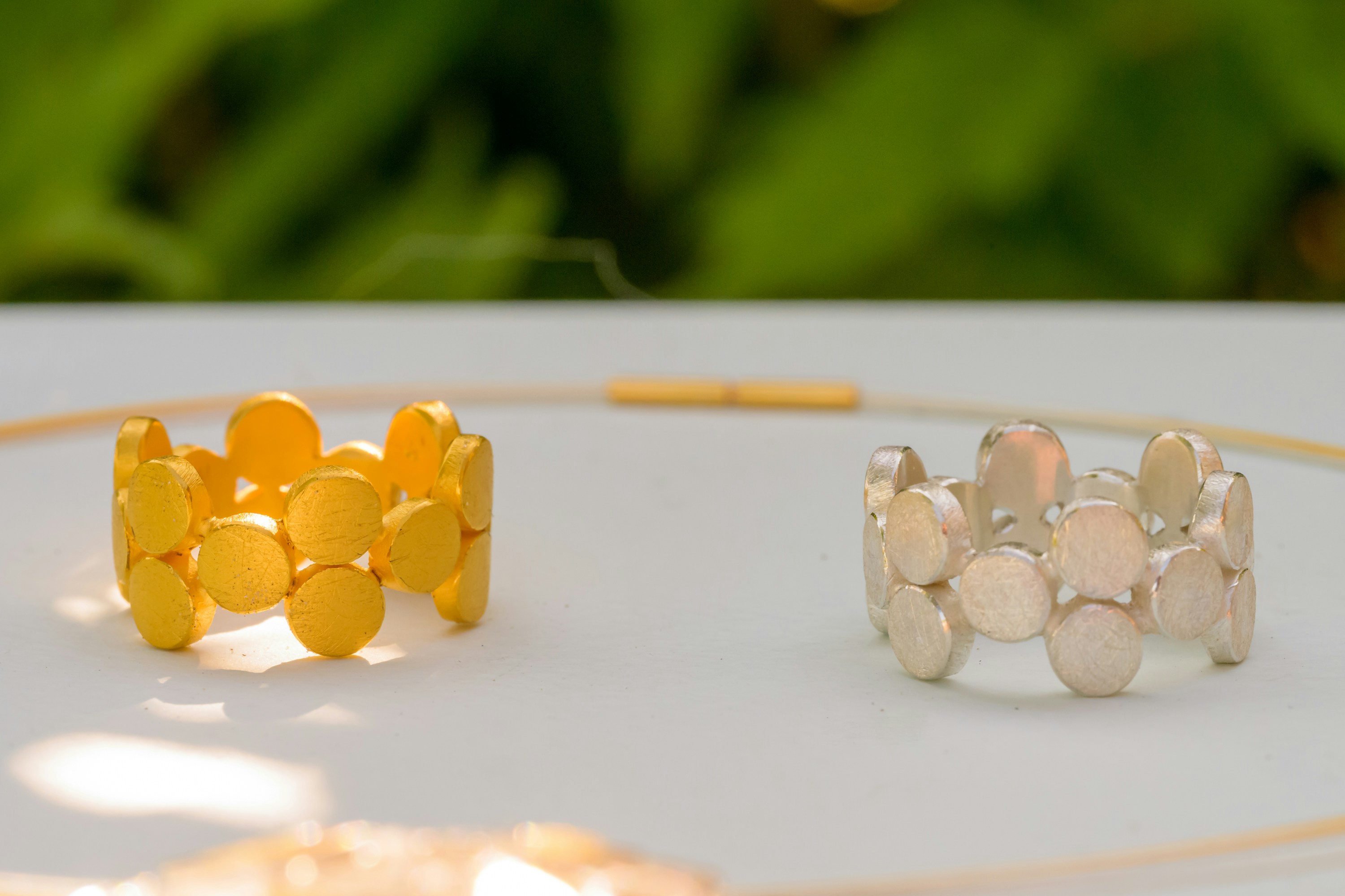 Twin Rings in Focus: Gold and Silver on a Sunlit Table