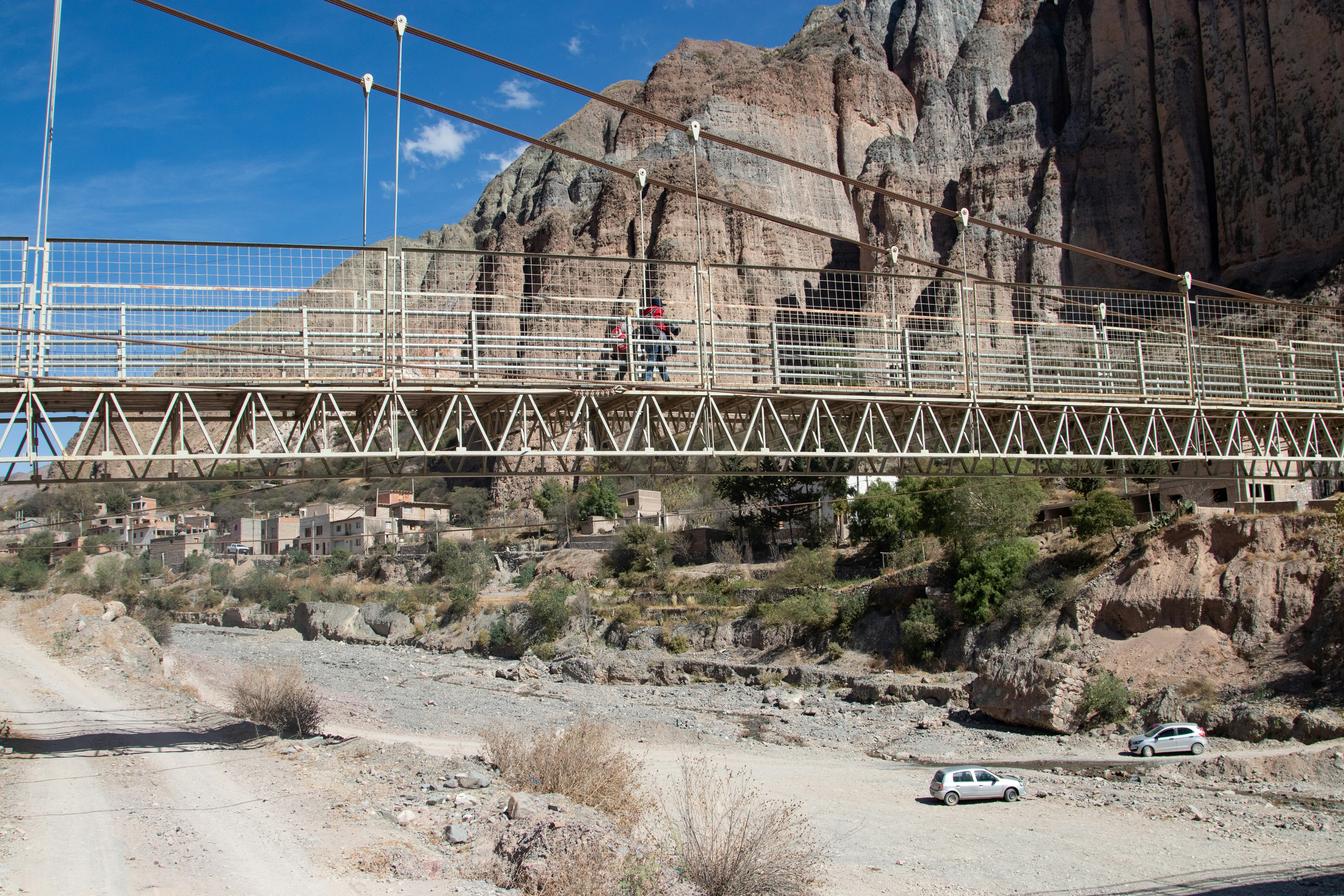 Desert Gorge Crossing: Pedestrians on a Weathered Suspension Bridge