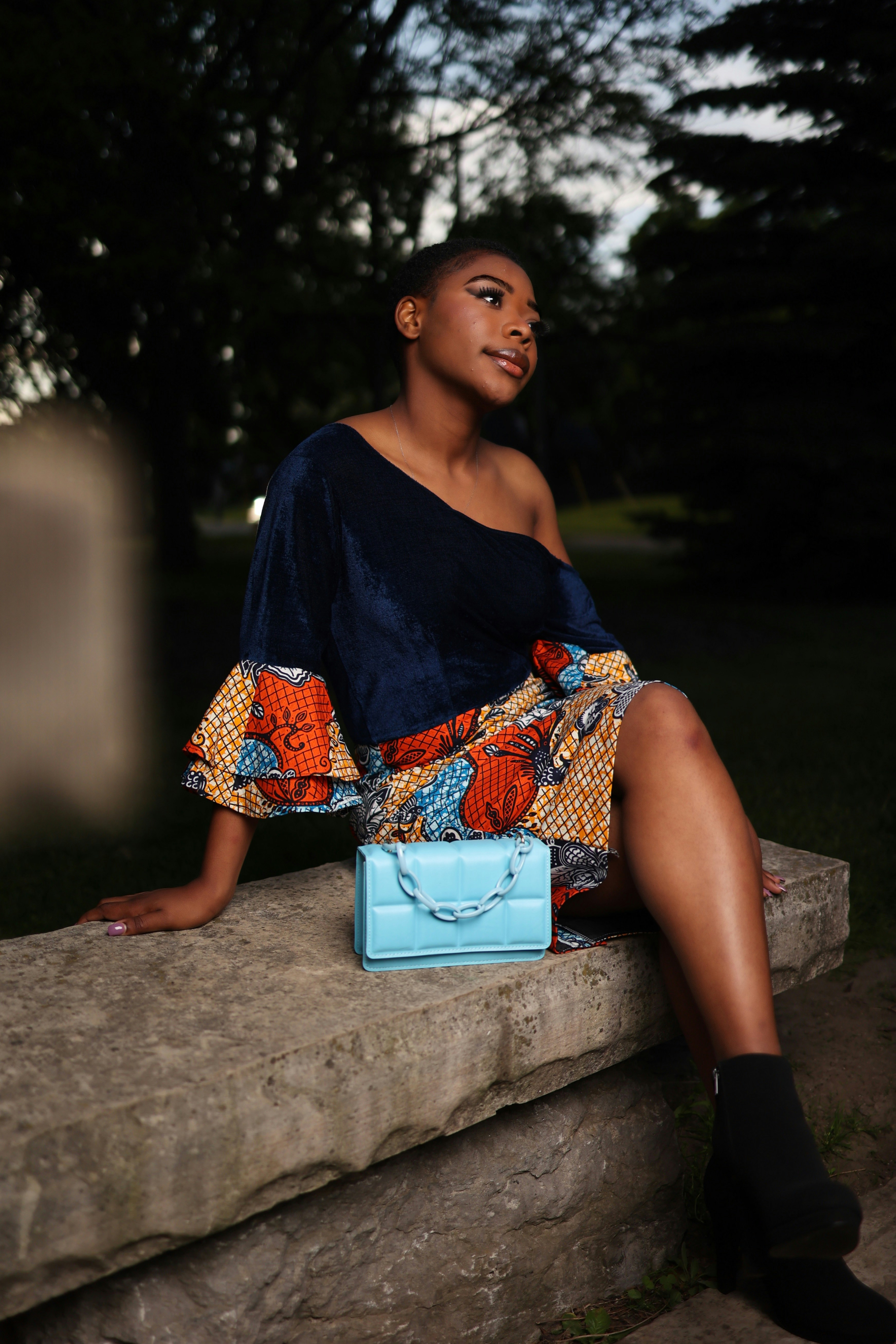 Twilight Poise: Indigo Off-Shoulder and Wax-Print Dress with Sky-Blue Handbag
