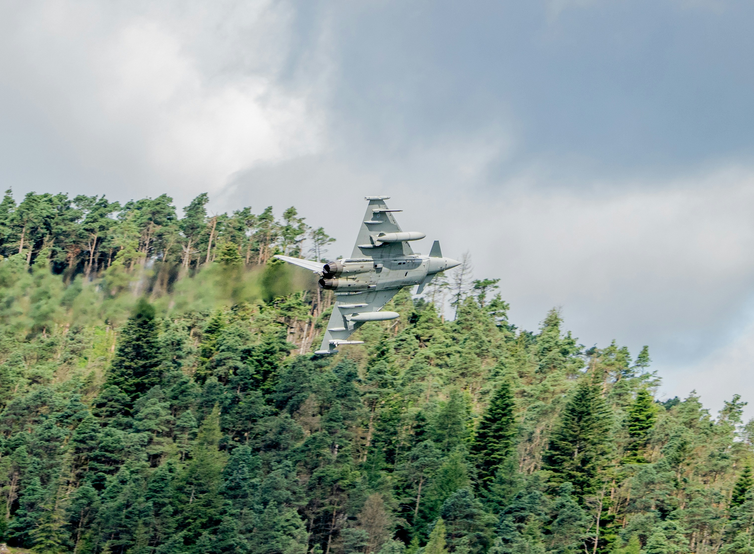 A military plane flying over trees photo – Free Great howe wood Image ...