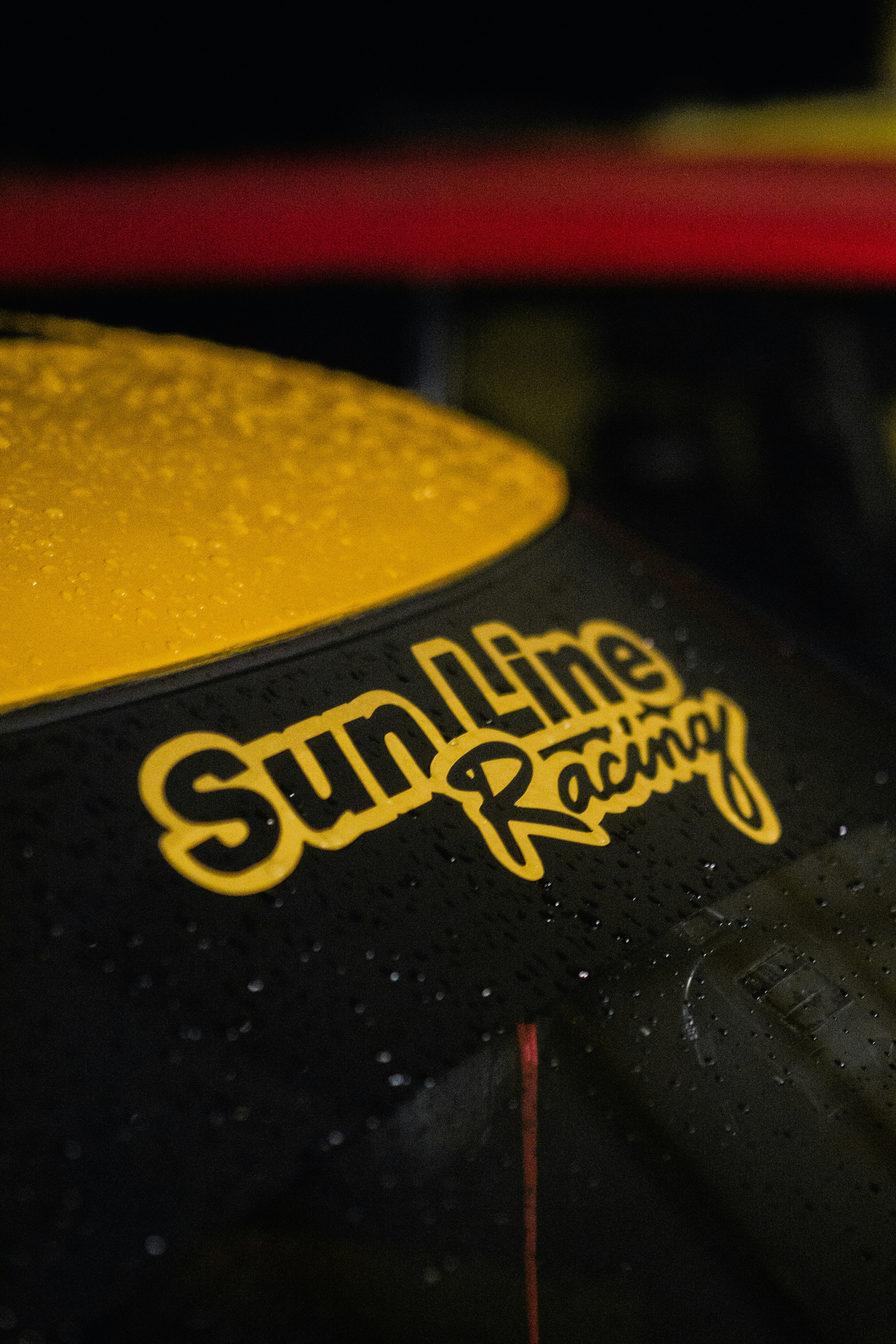 SunLine Racing Emblem on a Rain-Dusted Black Panel