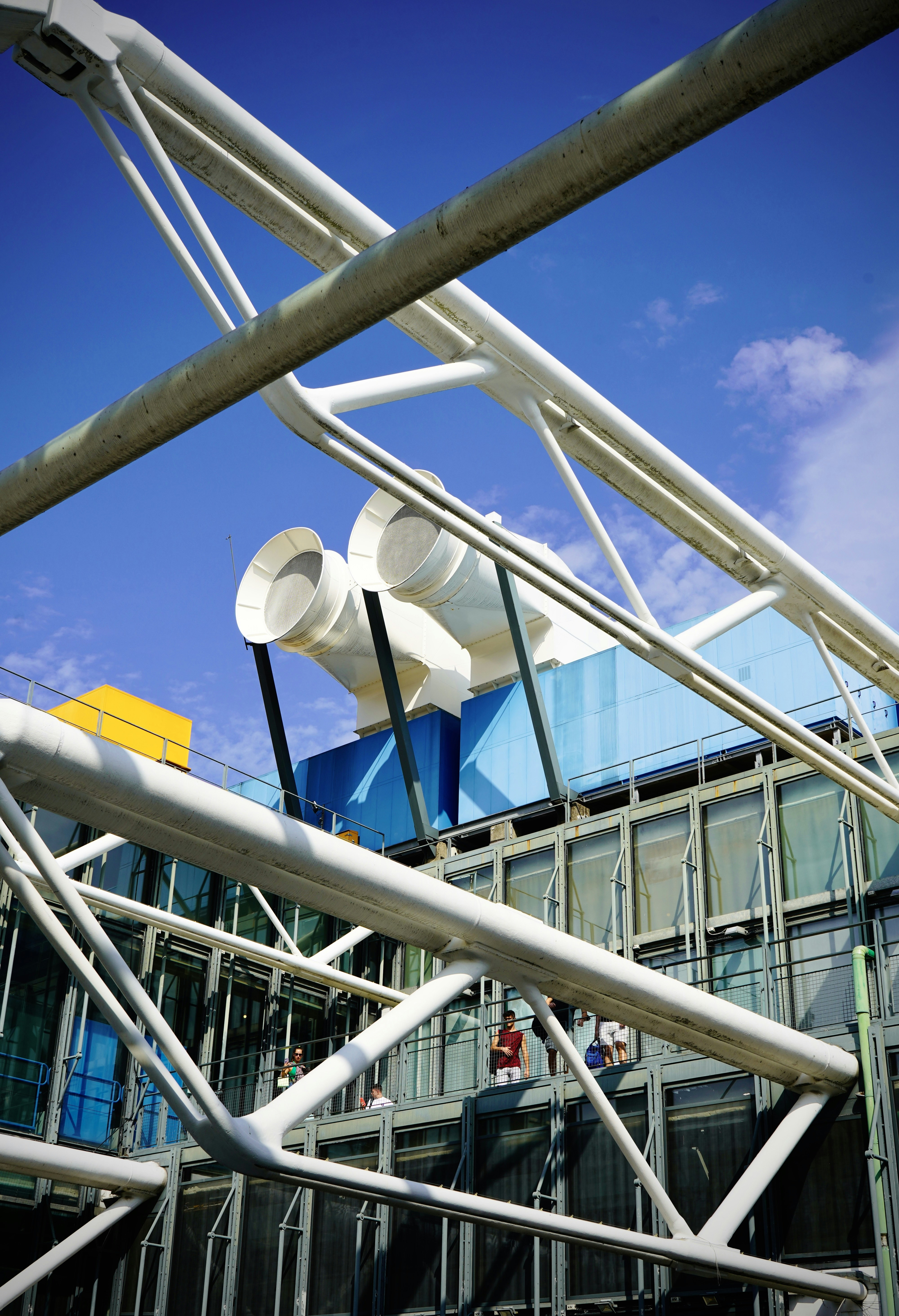 Crisscrossed Beams Framing a Glass Atrium Beneath a Cobalt Sky