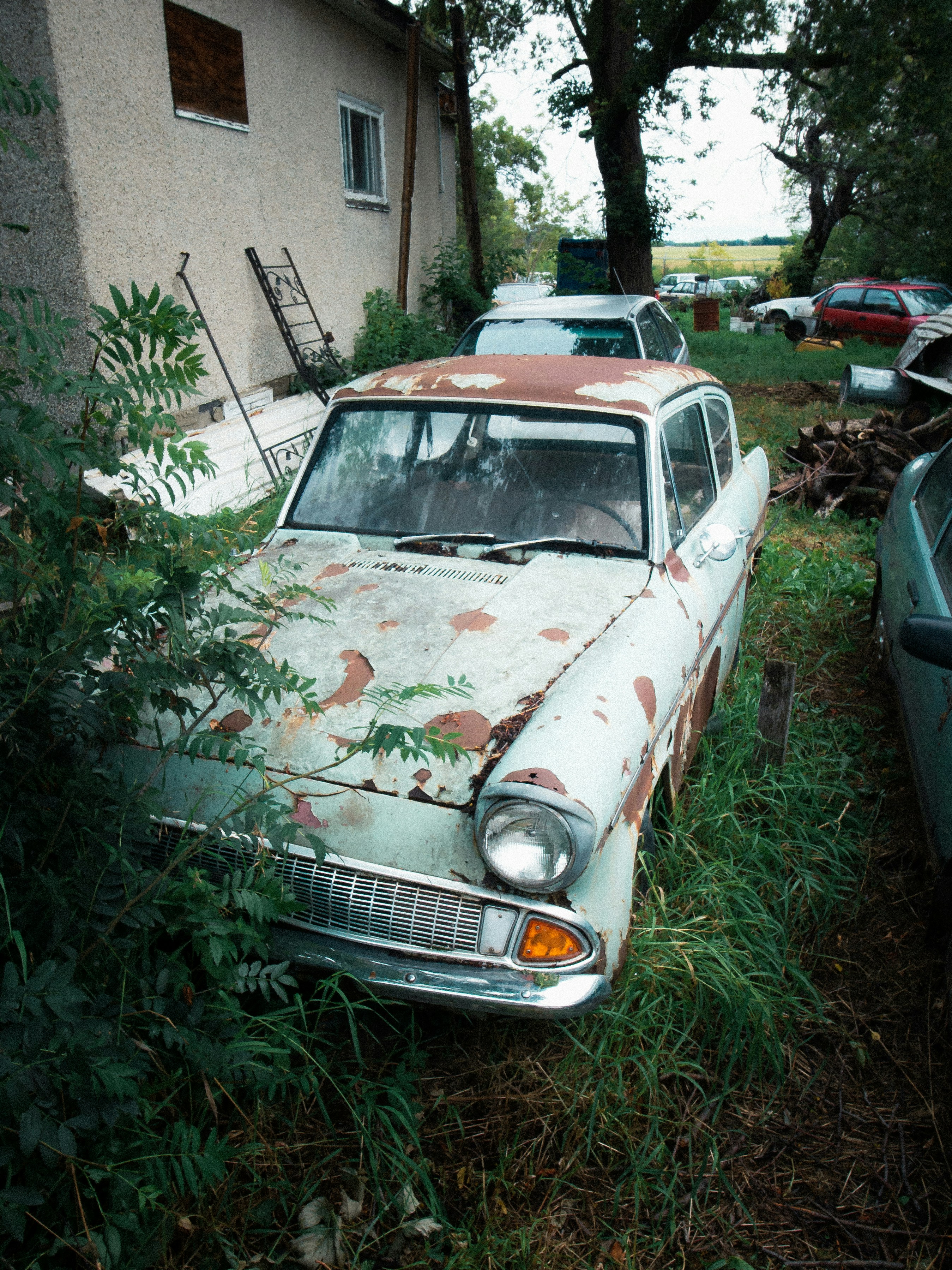 A old abandoned and rusted out car illustrating the rural decay | a car that has been in a ditch