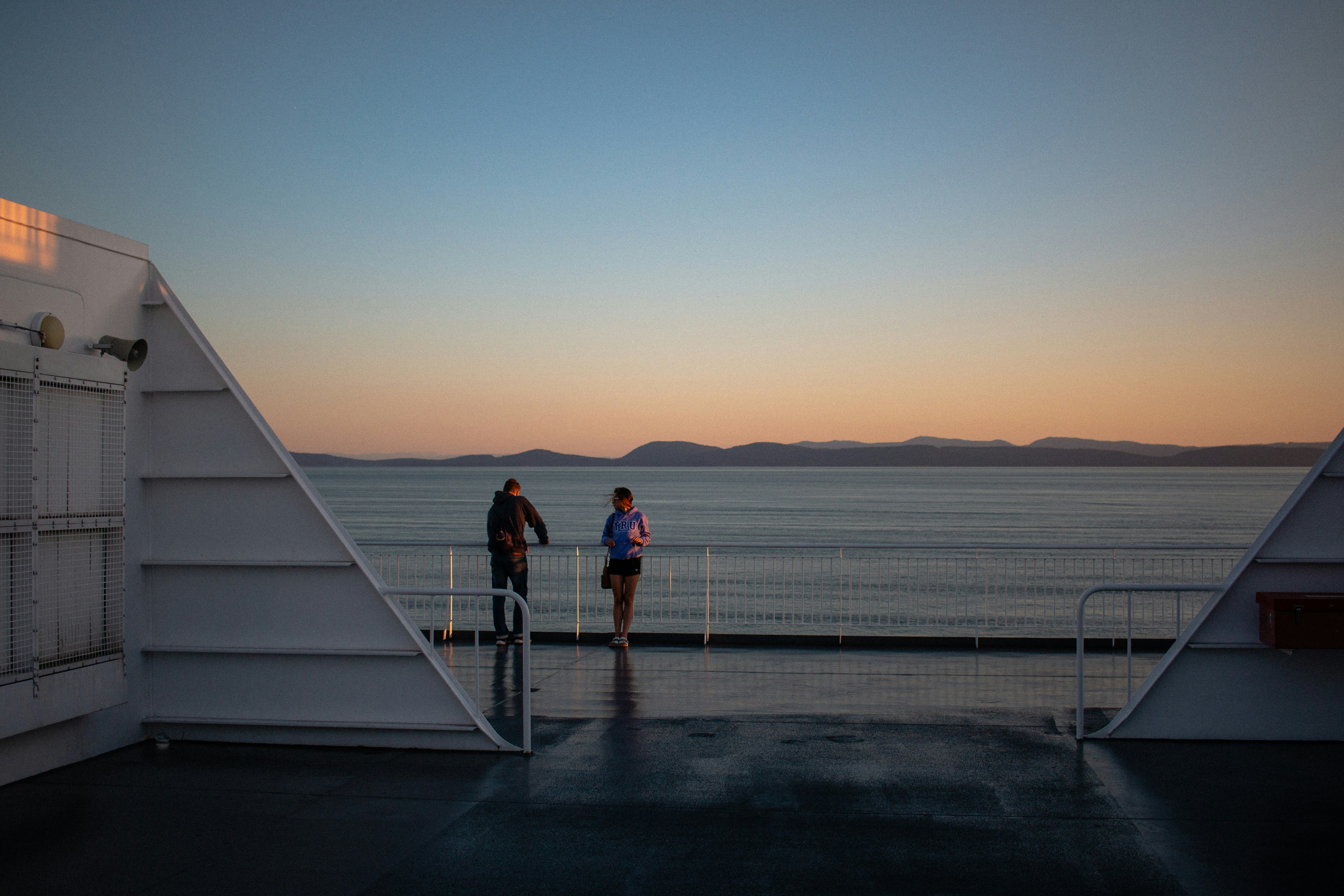 Two Figures at Distant Horizon: Evening Pause on a Ship Deck