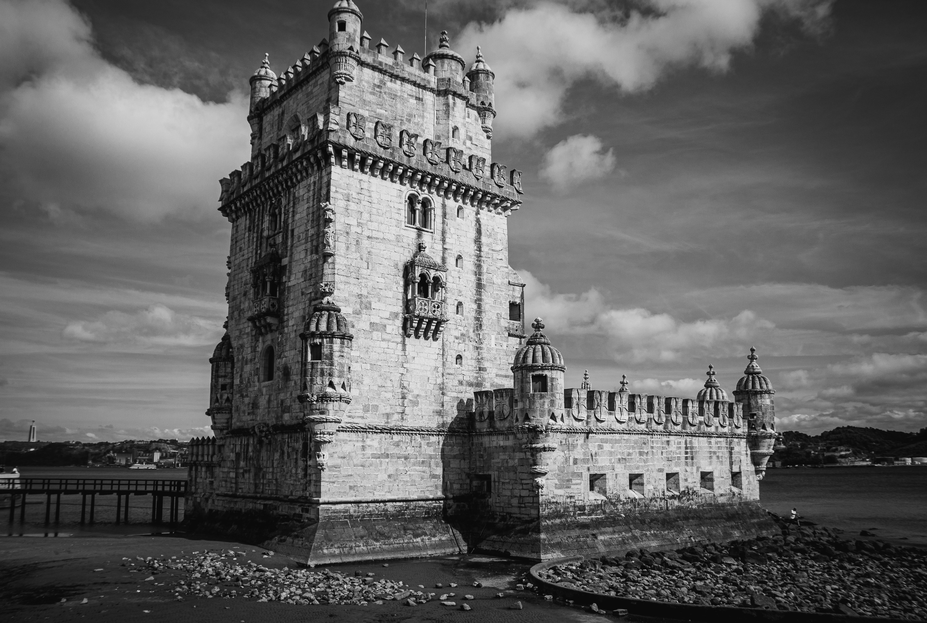 Foto Un castillo en una orilla rocosa con la Torre de Belém al fondo ...