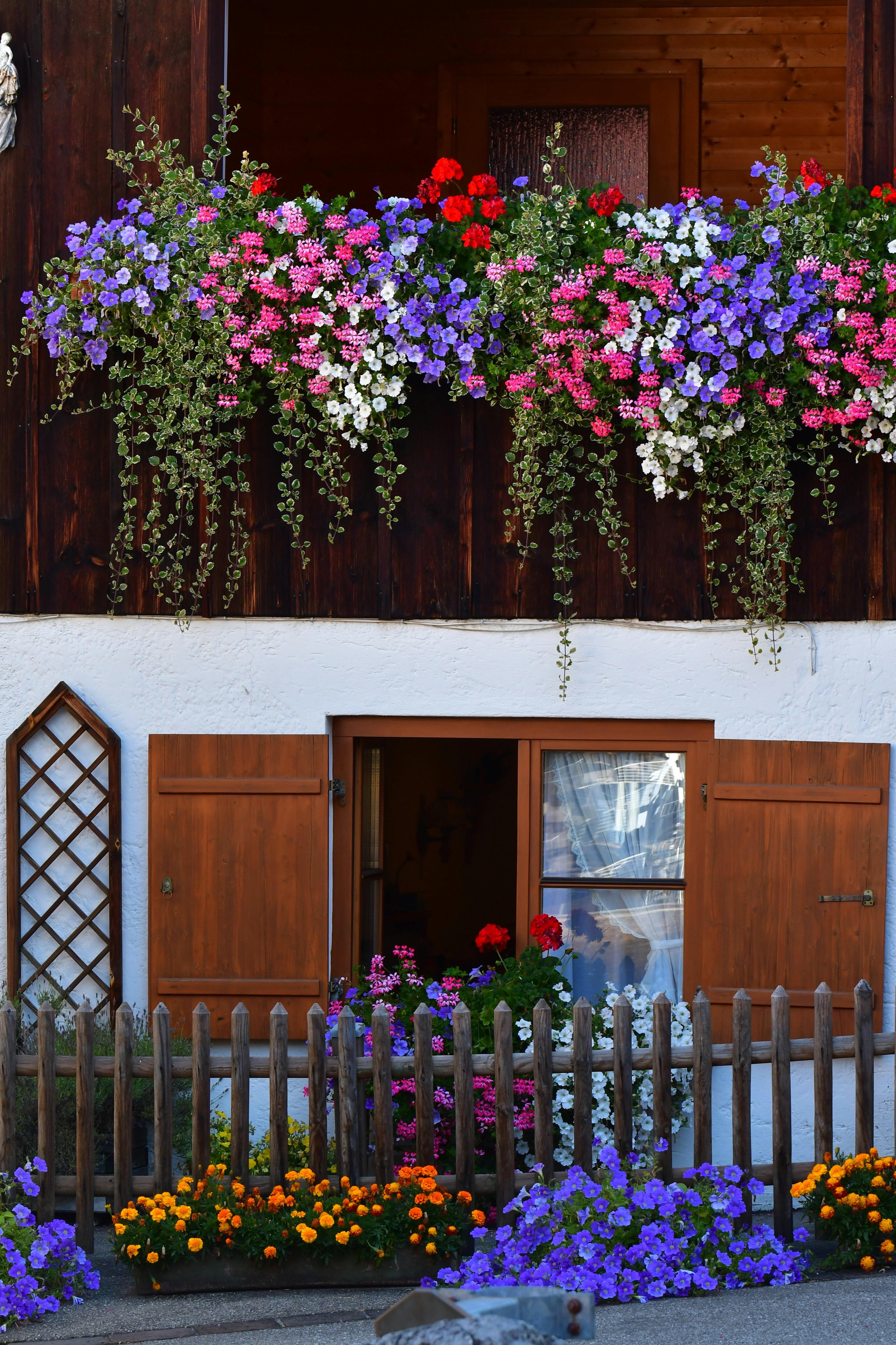 Colorful Balcony Blooms Framing a Wooden Chalet Window