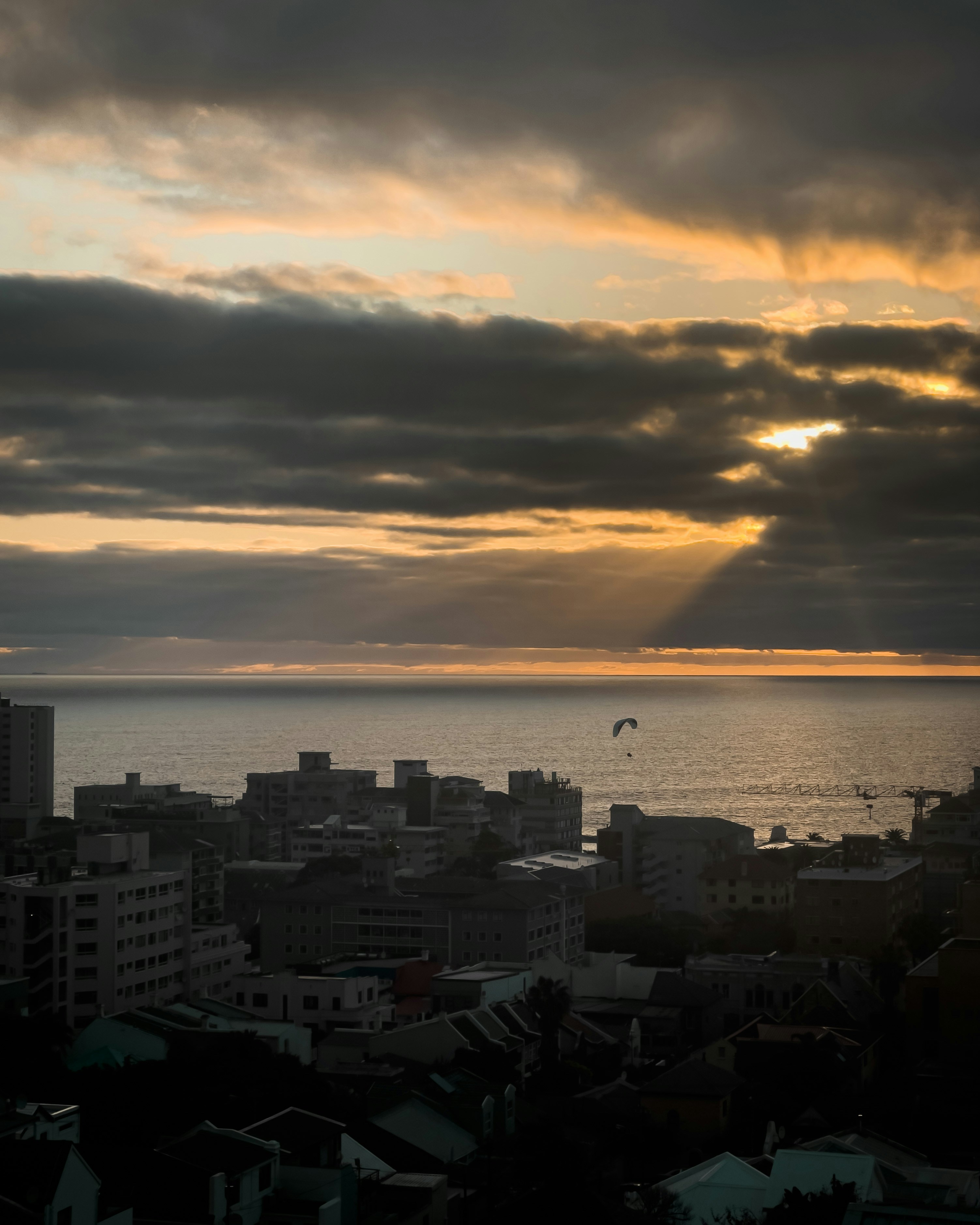 Dusk Sunbeams Rippling Across a Coastal City Skyline