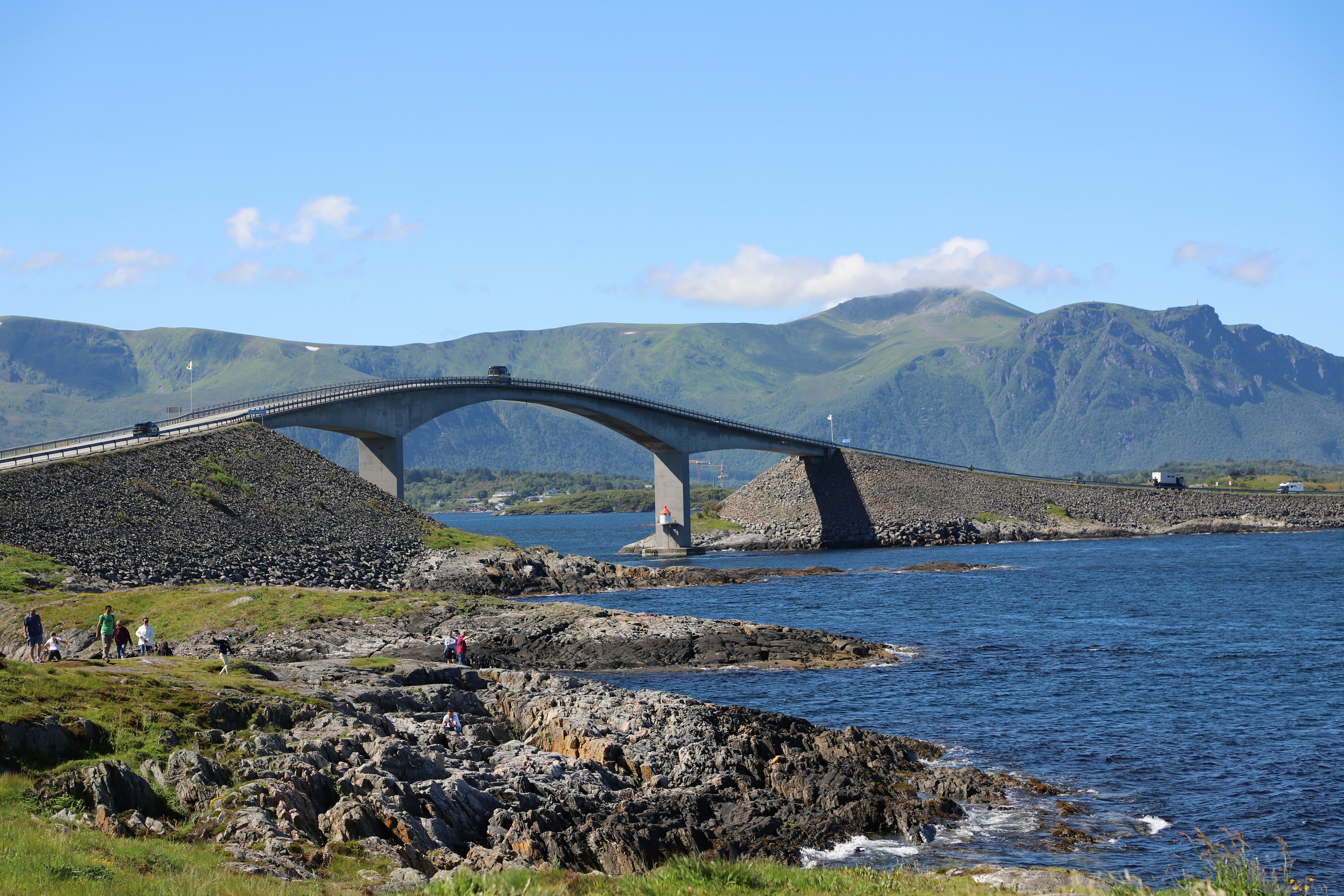 Stone Arch Over Blue Water: A Quiet Coastal Bridge Framed by Emerald Hills