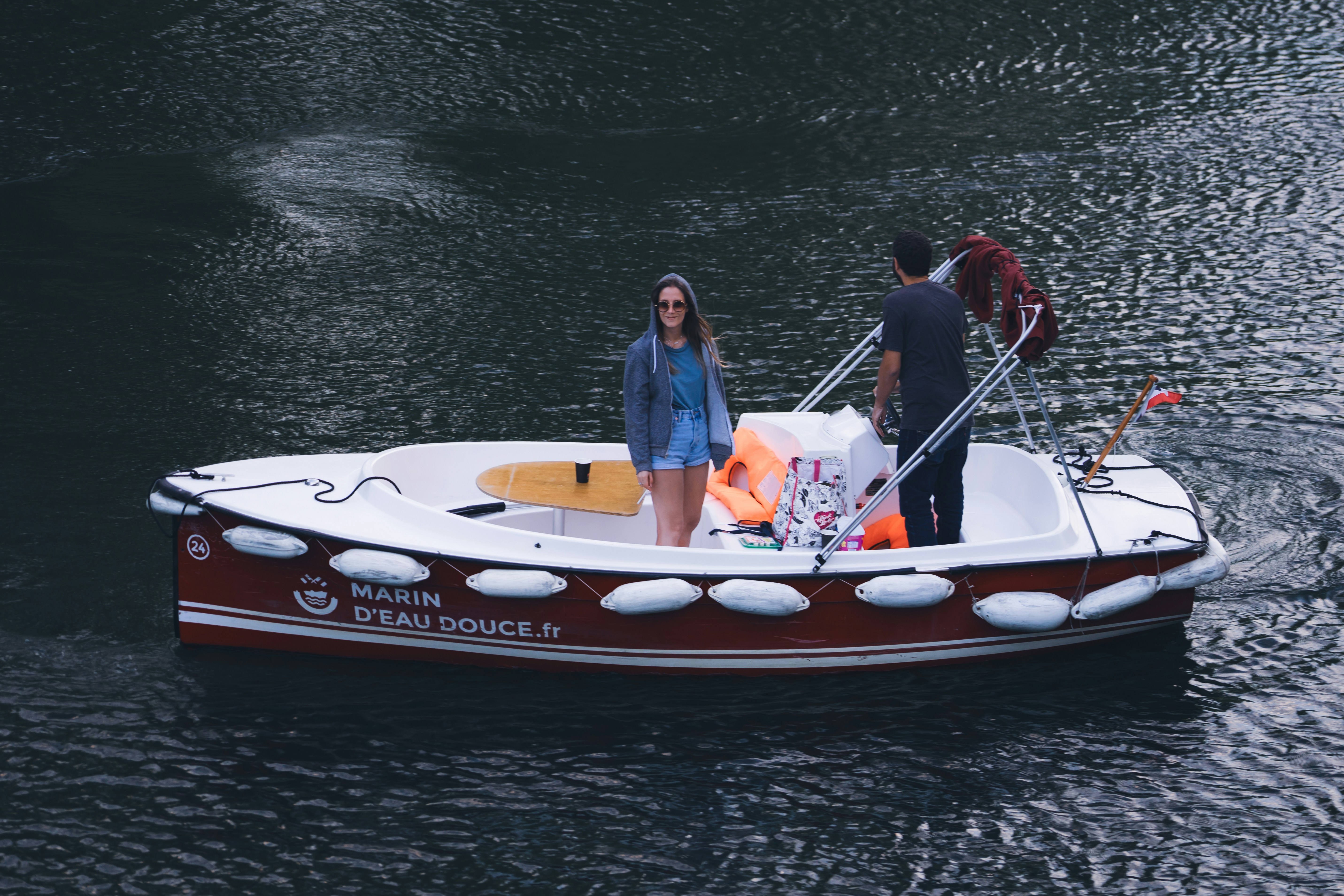 Two individuals aboard a small boat, surrounded by calm waters, embodying a serene day on the water.