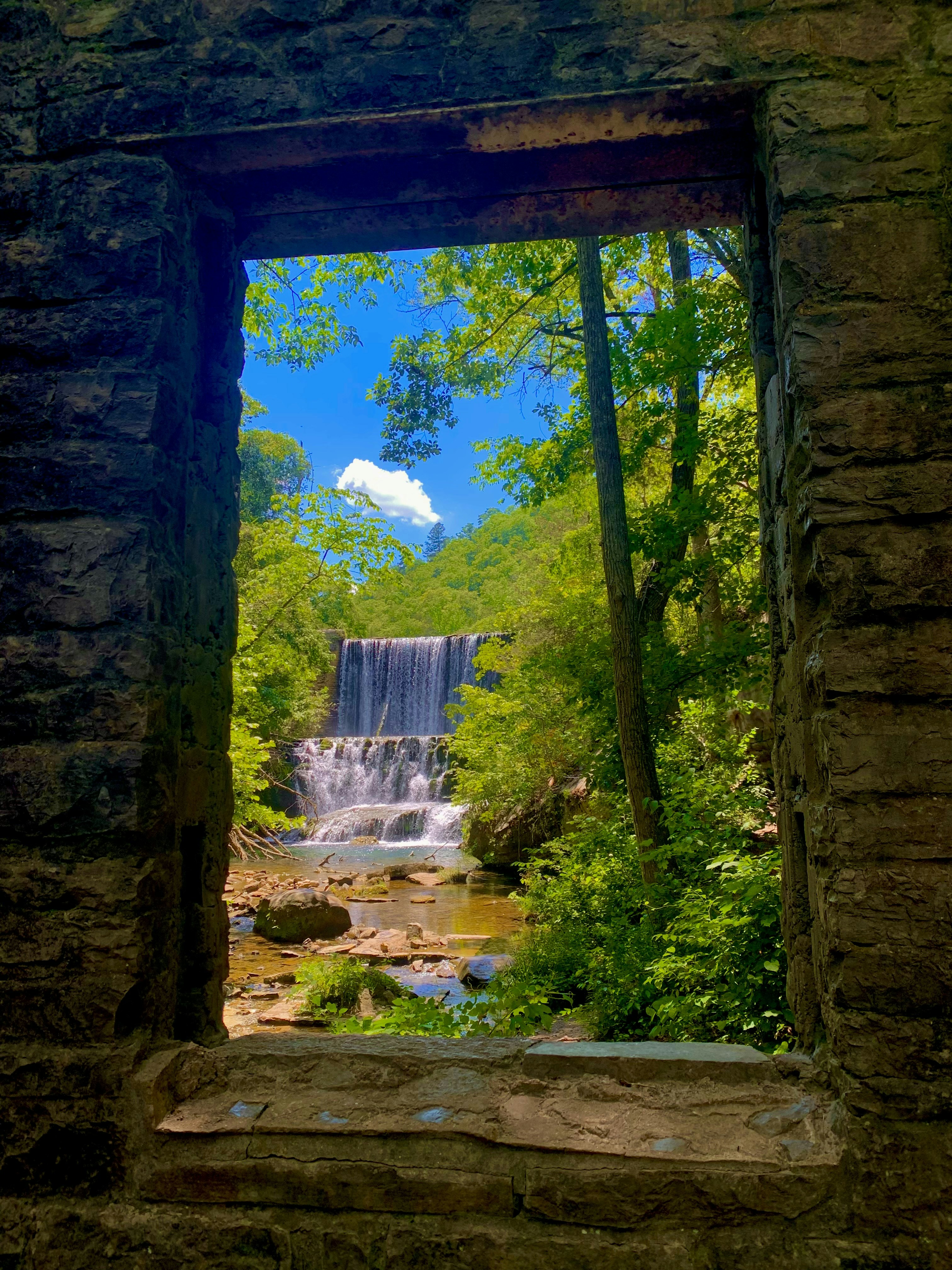 A view through a window of a waterfall and trees photo – Free Outdoors ...