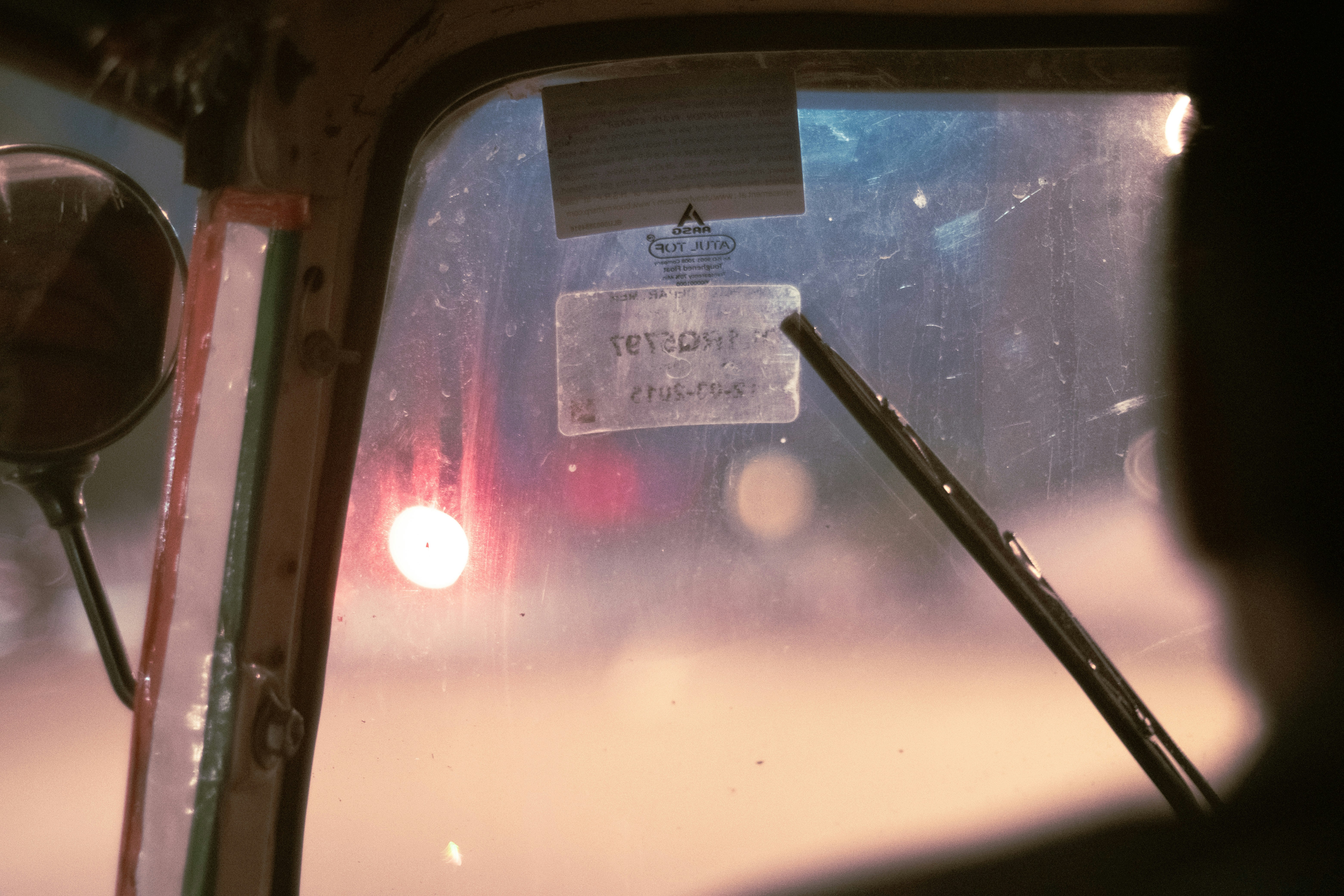 Stickered Window: A Backseat Gaze Through Blurred Night Traffic