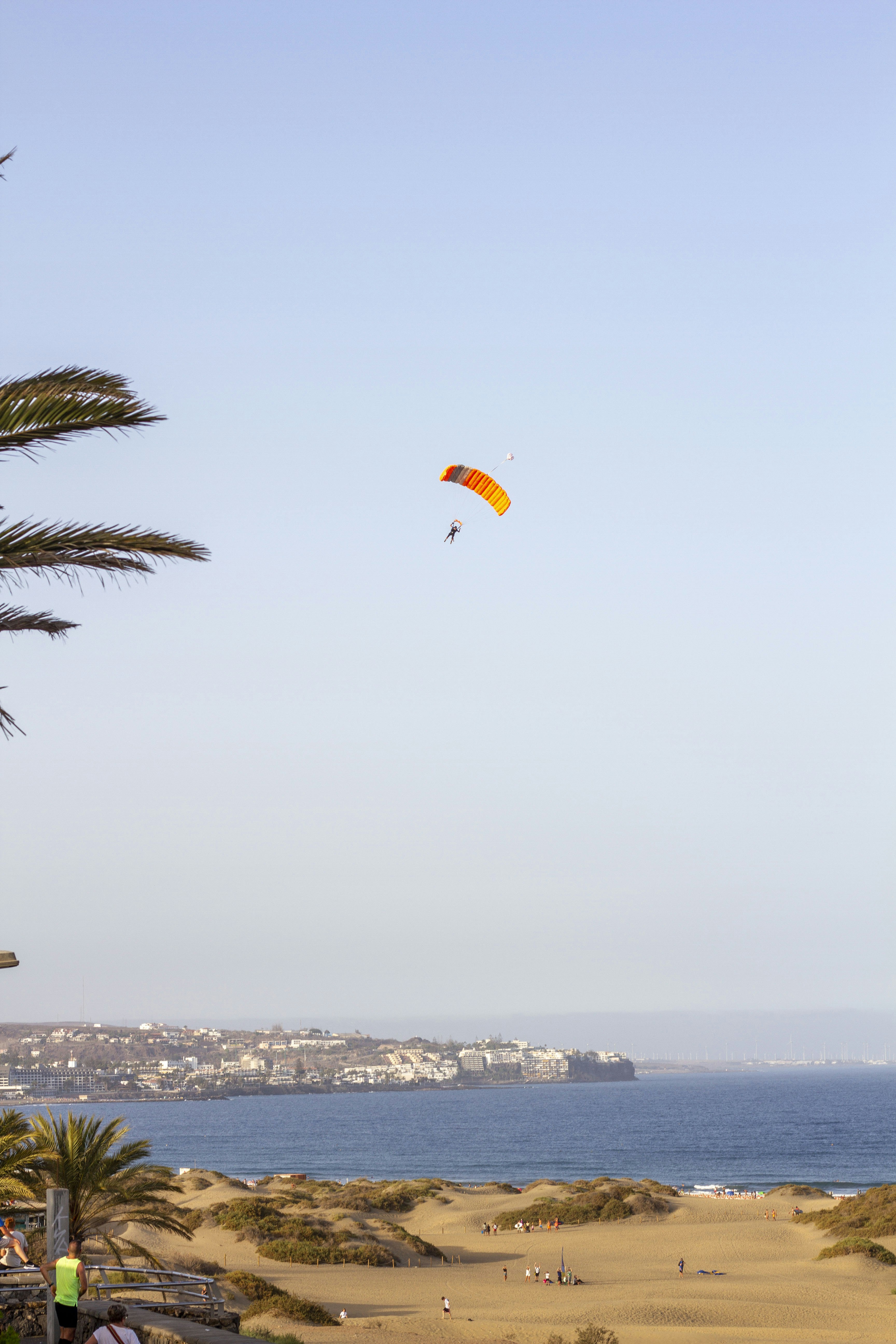 Orange Paraglider Soaring Above a Quiet Coastal Dune