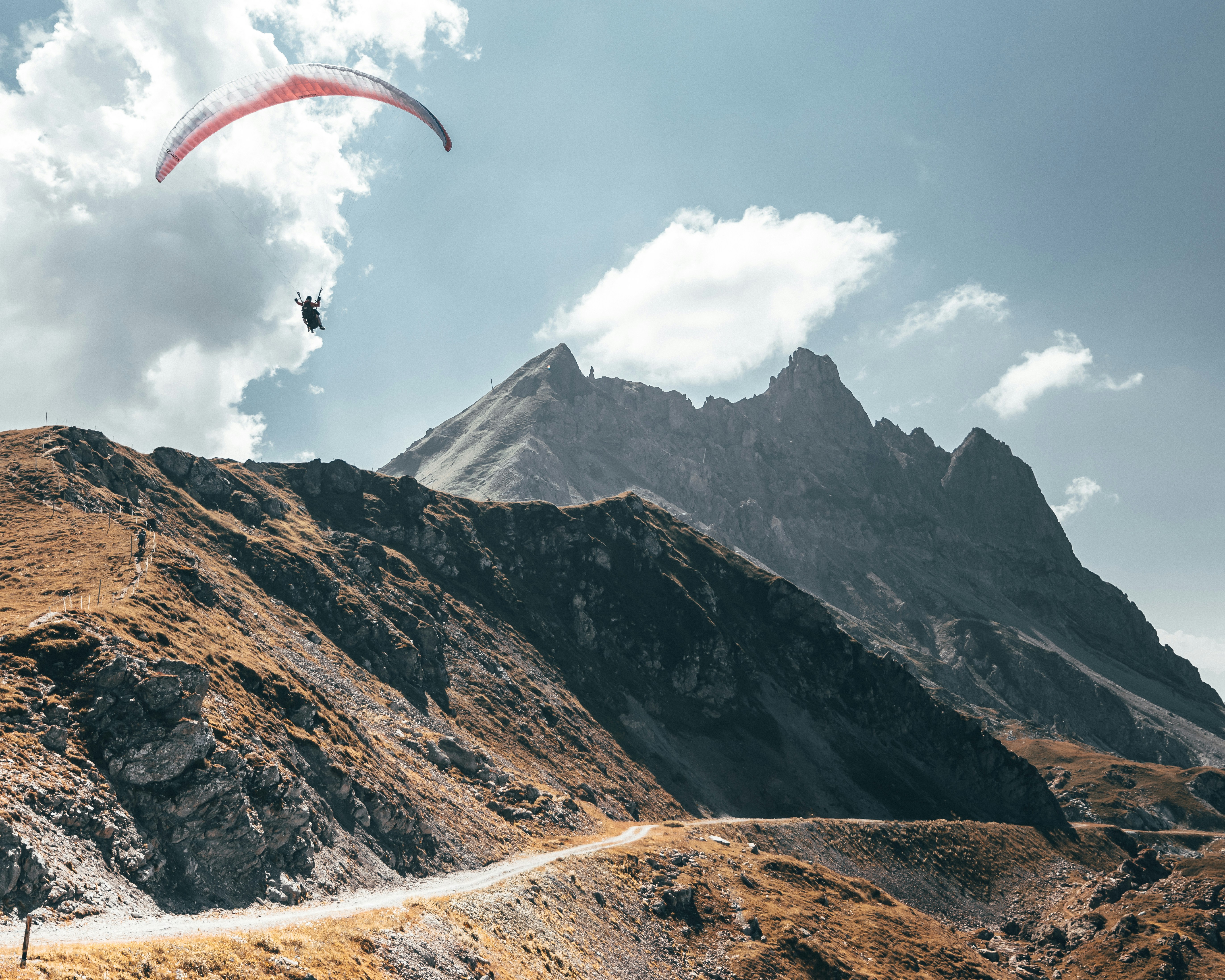 A person parachuting over a mountain photo – Free Switzerland Image on ...