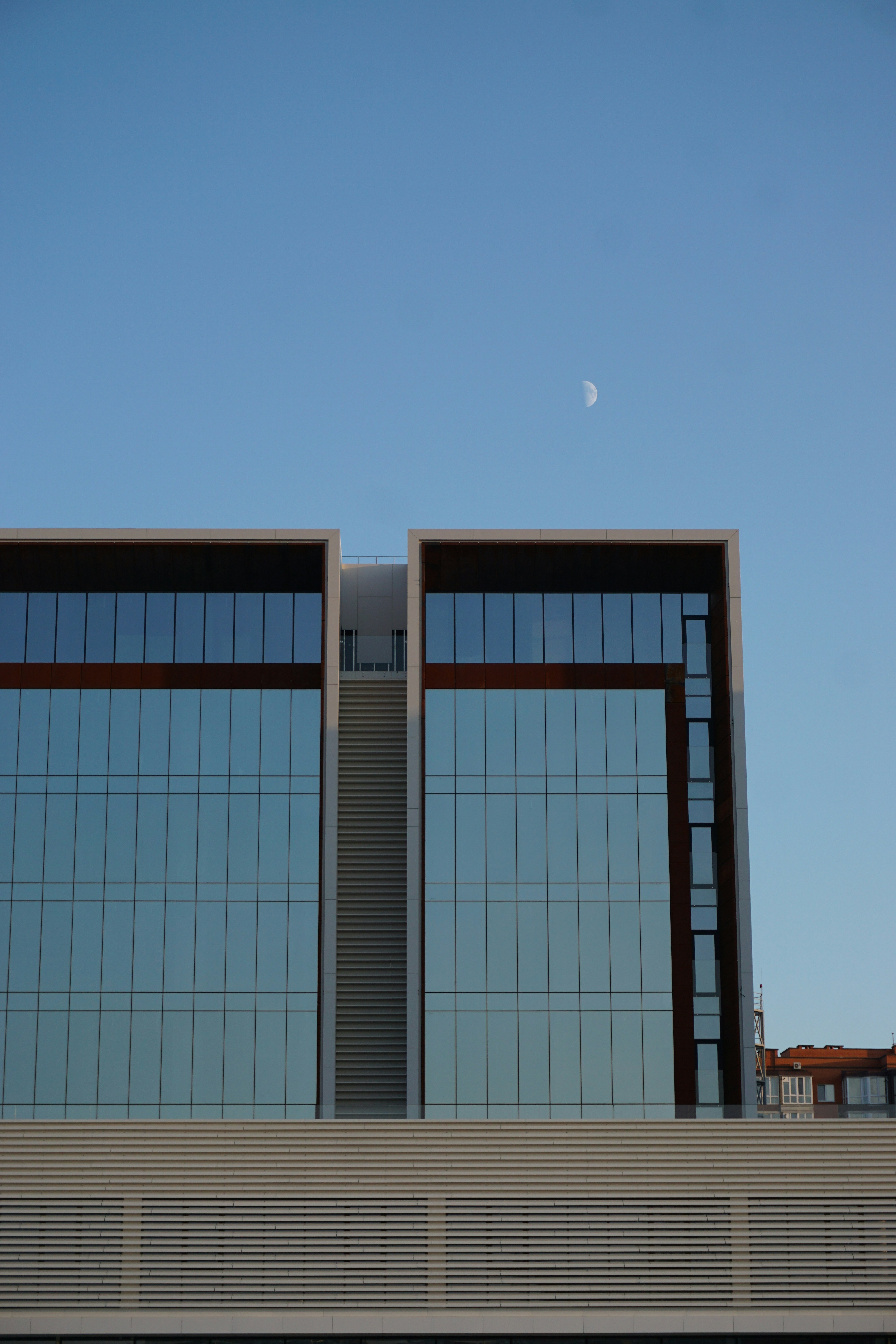 Twin Glass Facades Framing a Crescent Sky