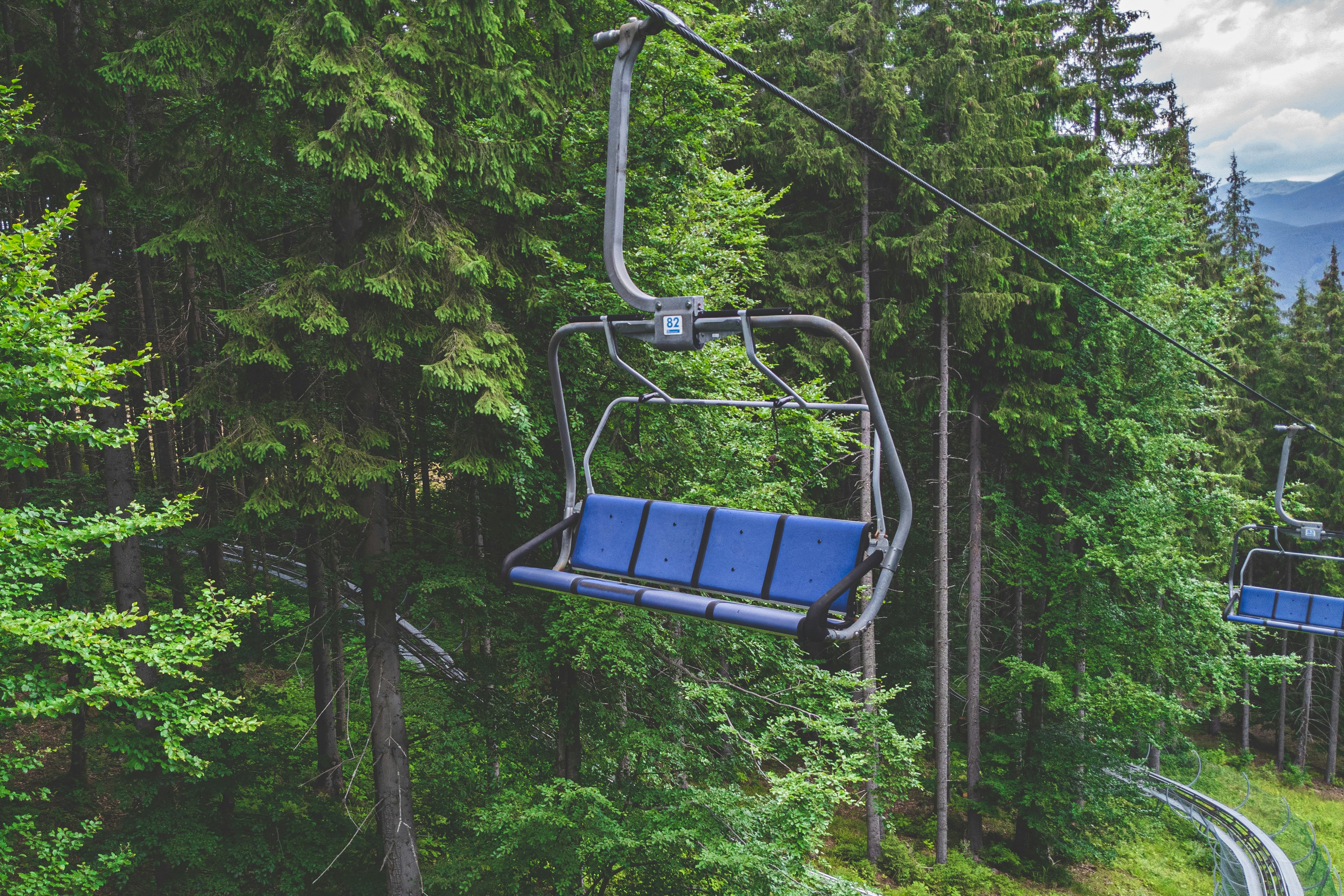 Blue Chairlift Above the Pine Canopy: A Quiet Alpine Ascent