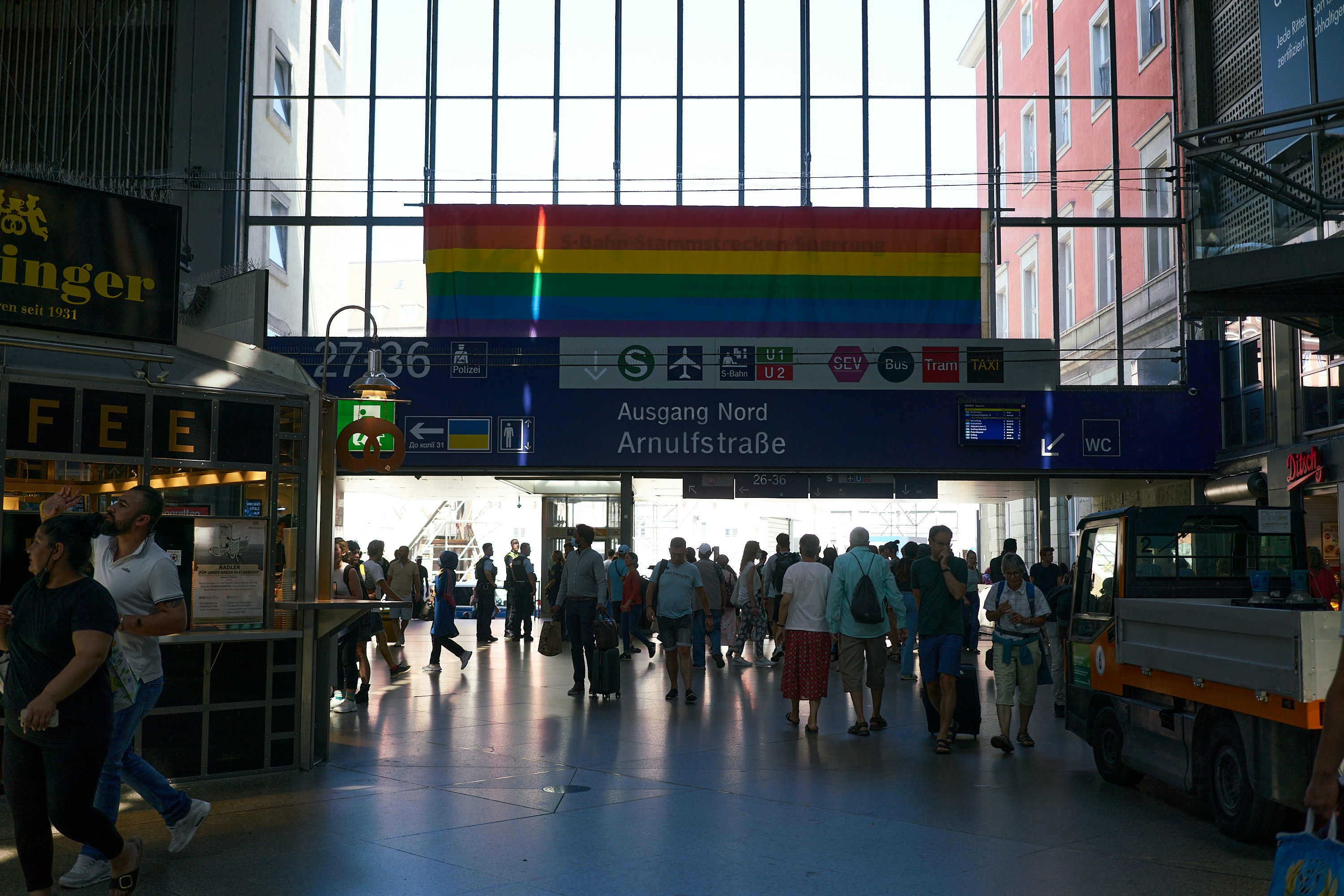 Rainbow Banner Over a Busy Station Entrance