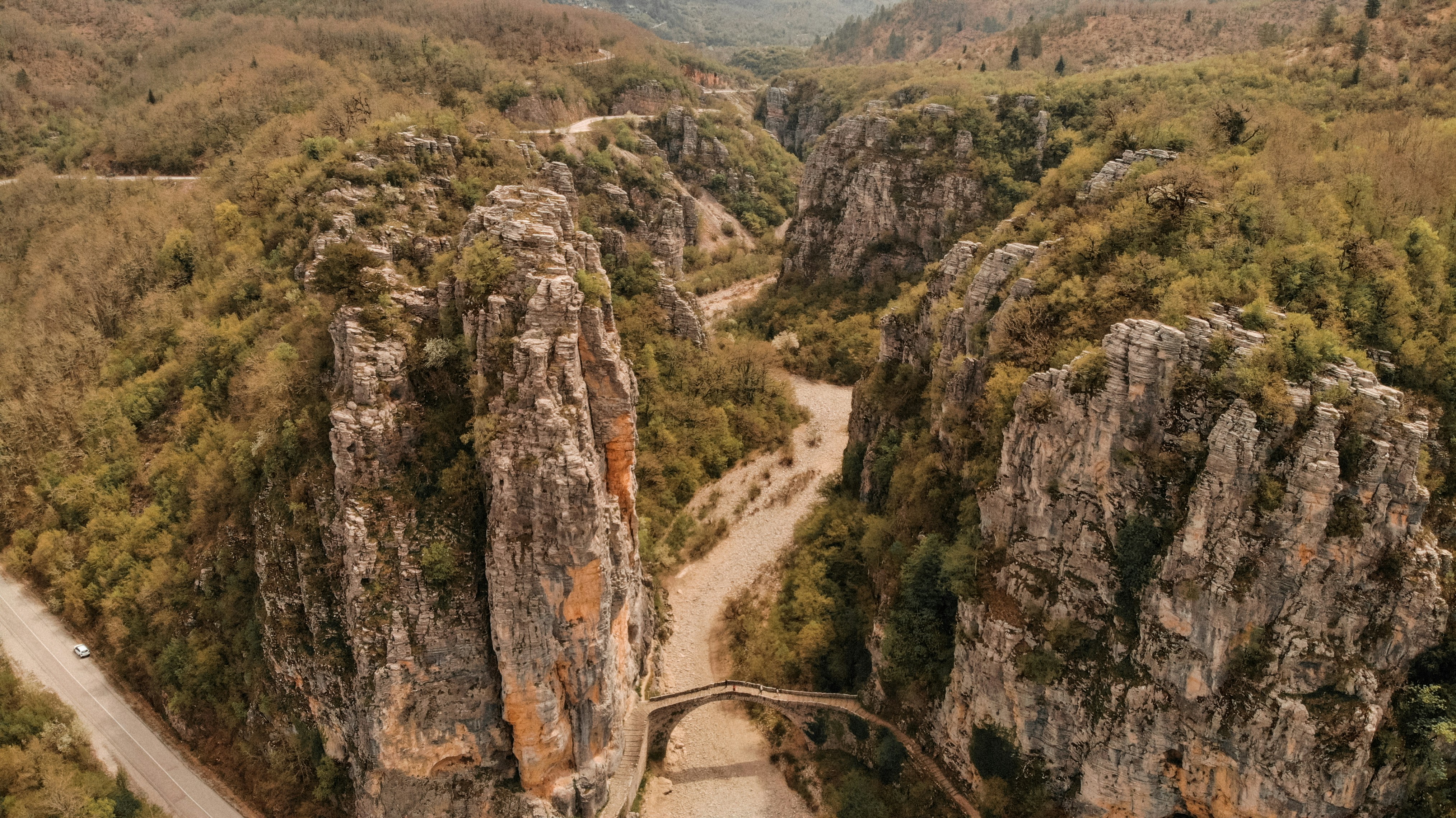 Bridge Between Giants: A Narrow Arc Spanning a Canyon of Weathered Cliffs