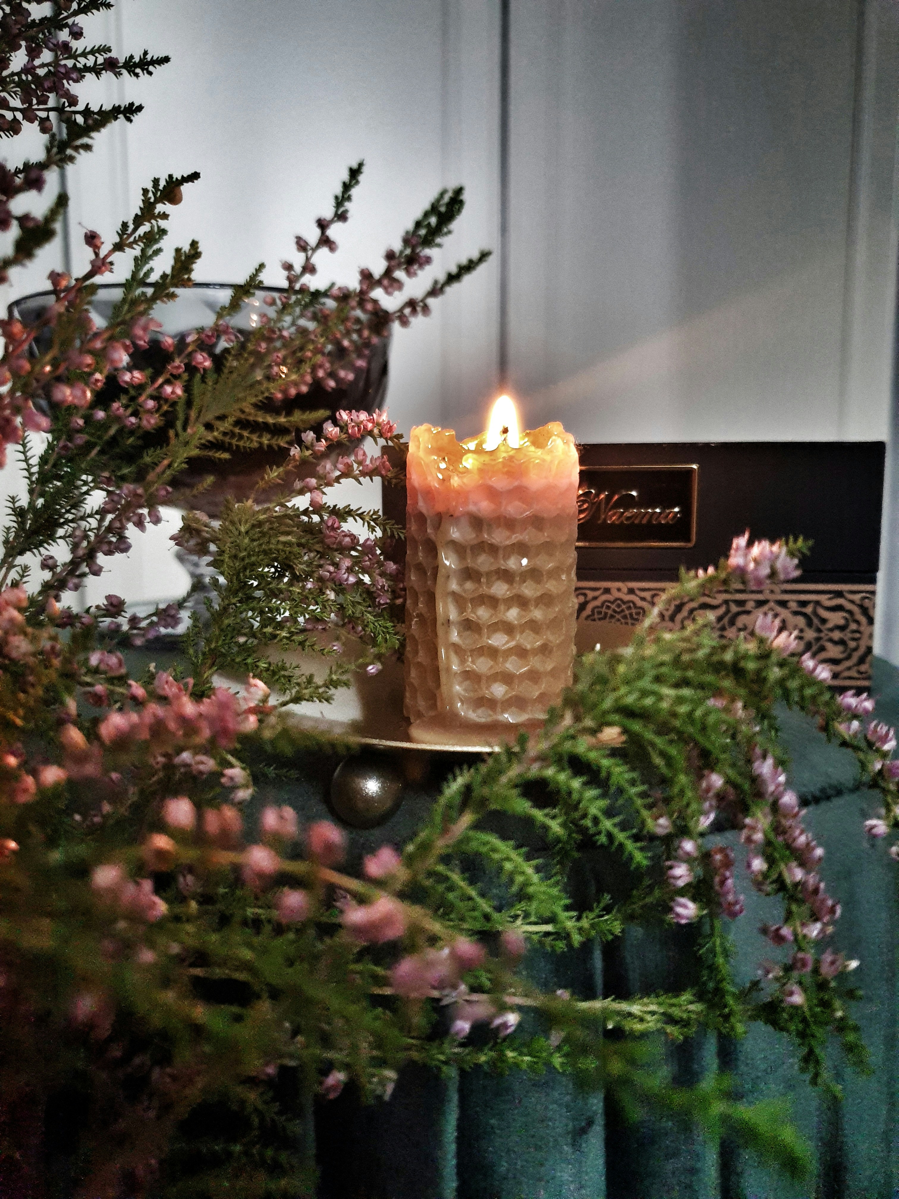 Candlelit still life among delicate florals and a radiant honeycomb candle