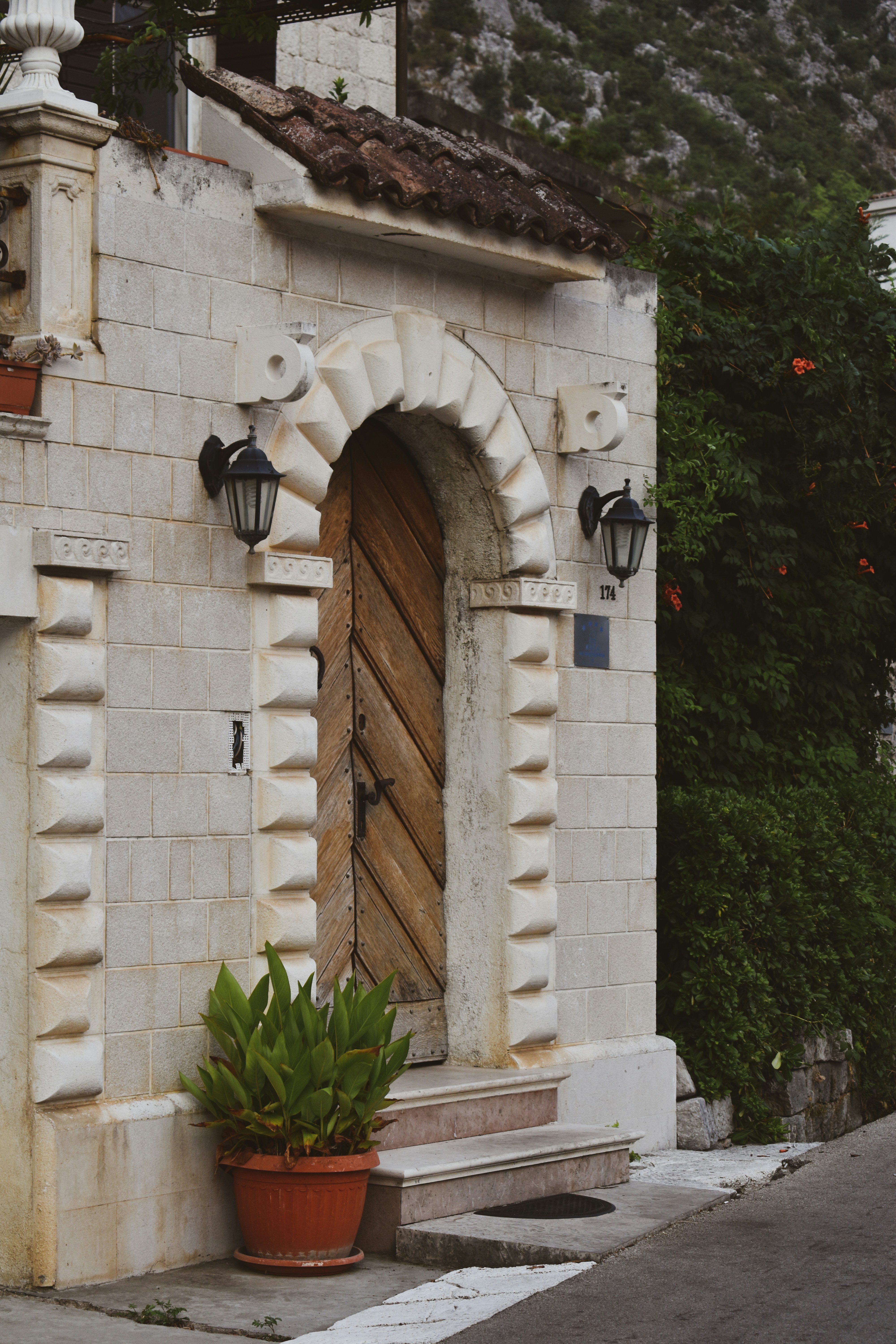 Weathered Archway on a Quiet Stone Facade with Lanterns