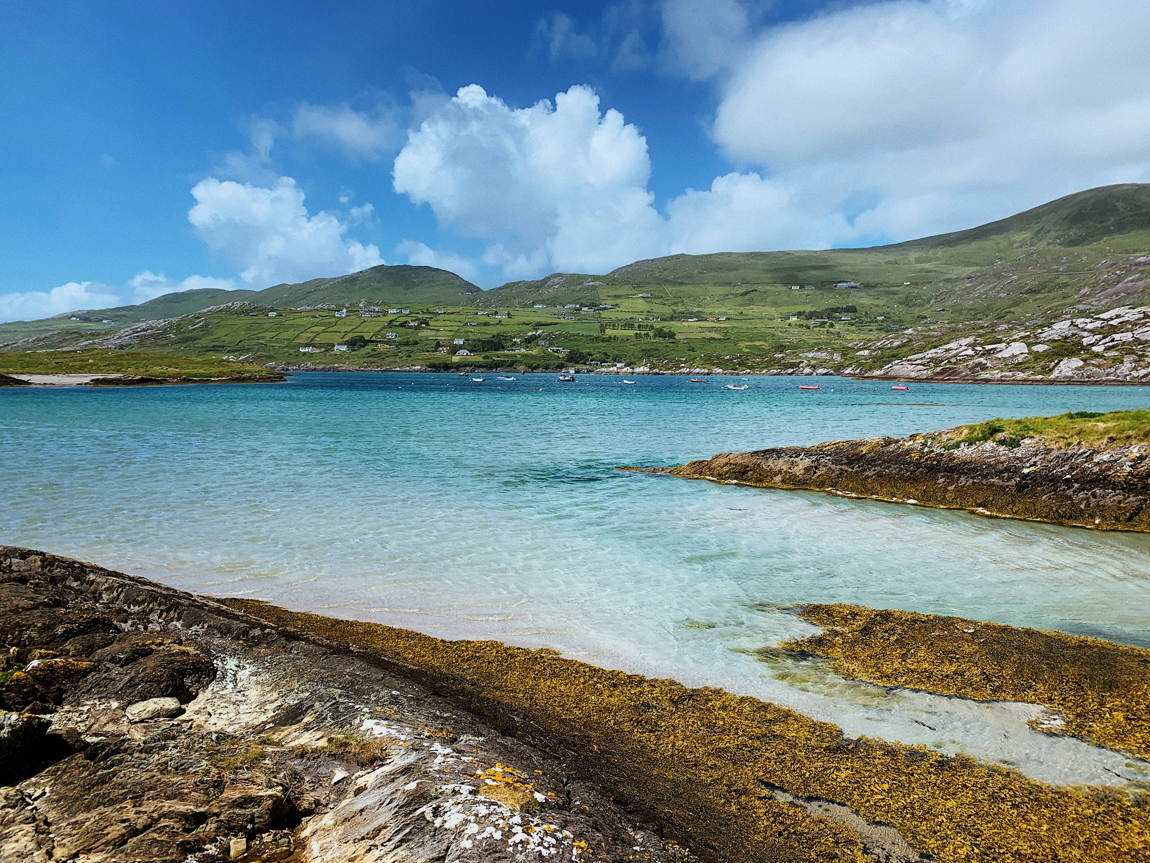 Turquoise Cove Between Rocky Foreground and Emerald Slopes