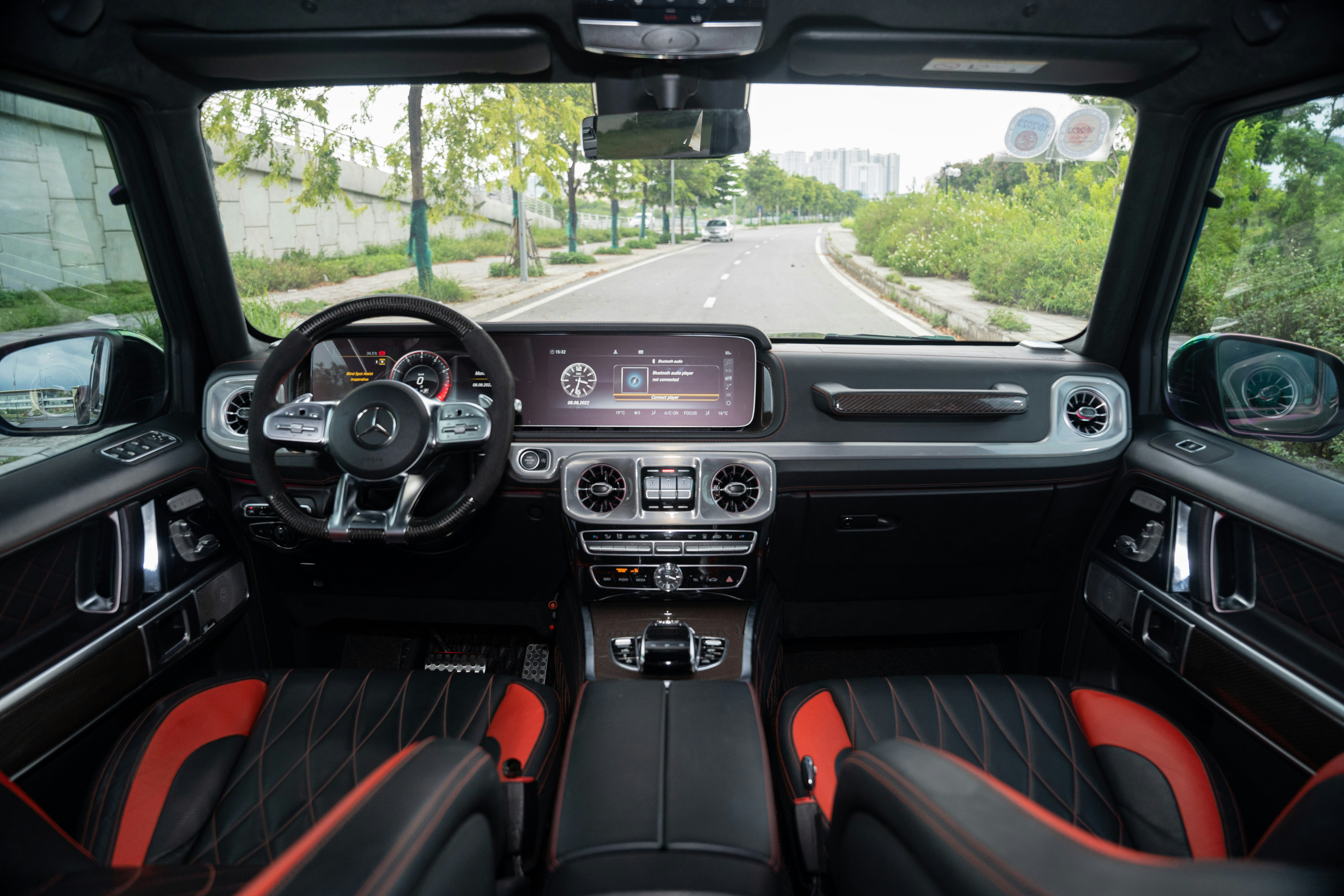Interior view of a Mercedes-Benz G-Class showcasing a sleek dashboard, advanced infotainment system, and premium seating. The design reflects a blend of luxury and cutting-edge technology.
