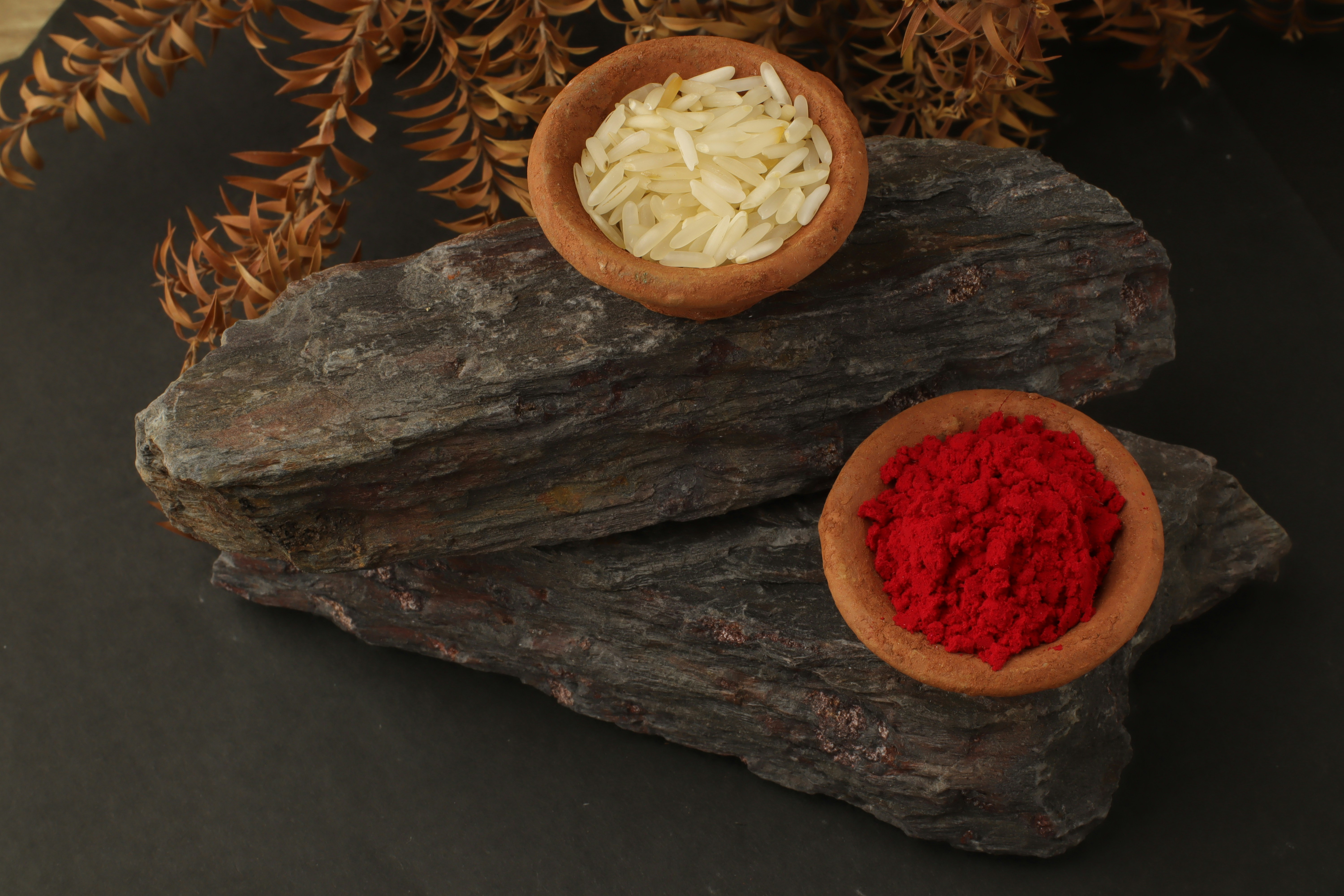 Rough-hewn slate with bowls of white rice and red powder