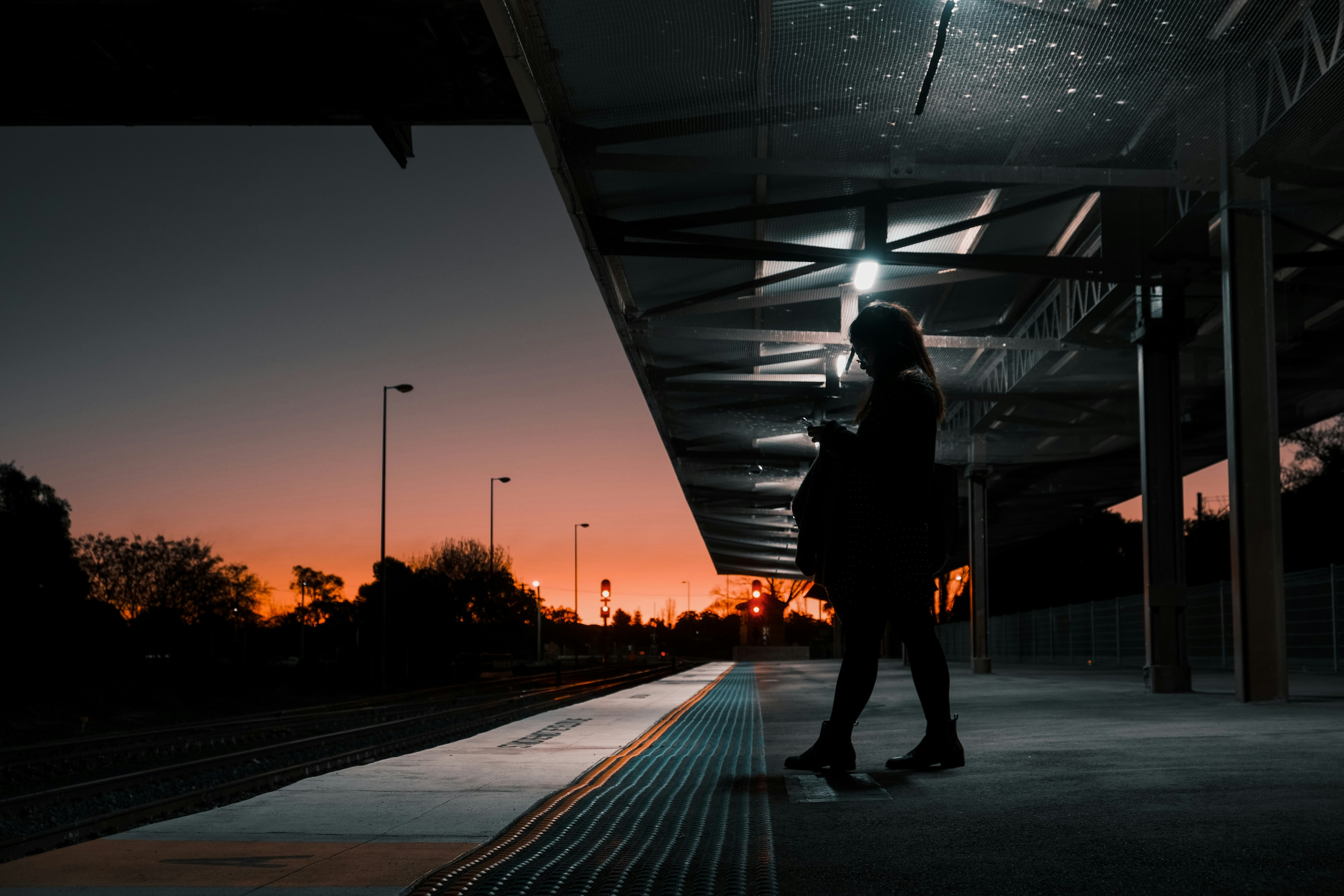 Dusk Platform Silhouette: A Photographer Pauses at the Edge of Day