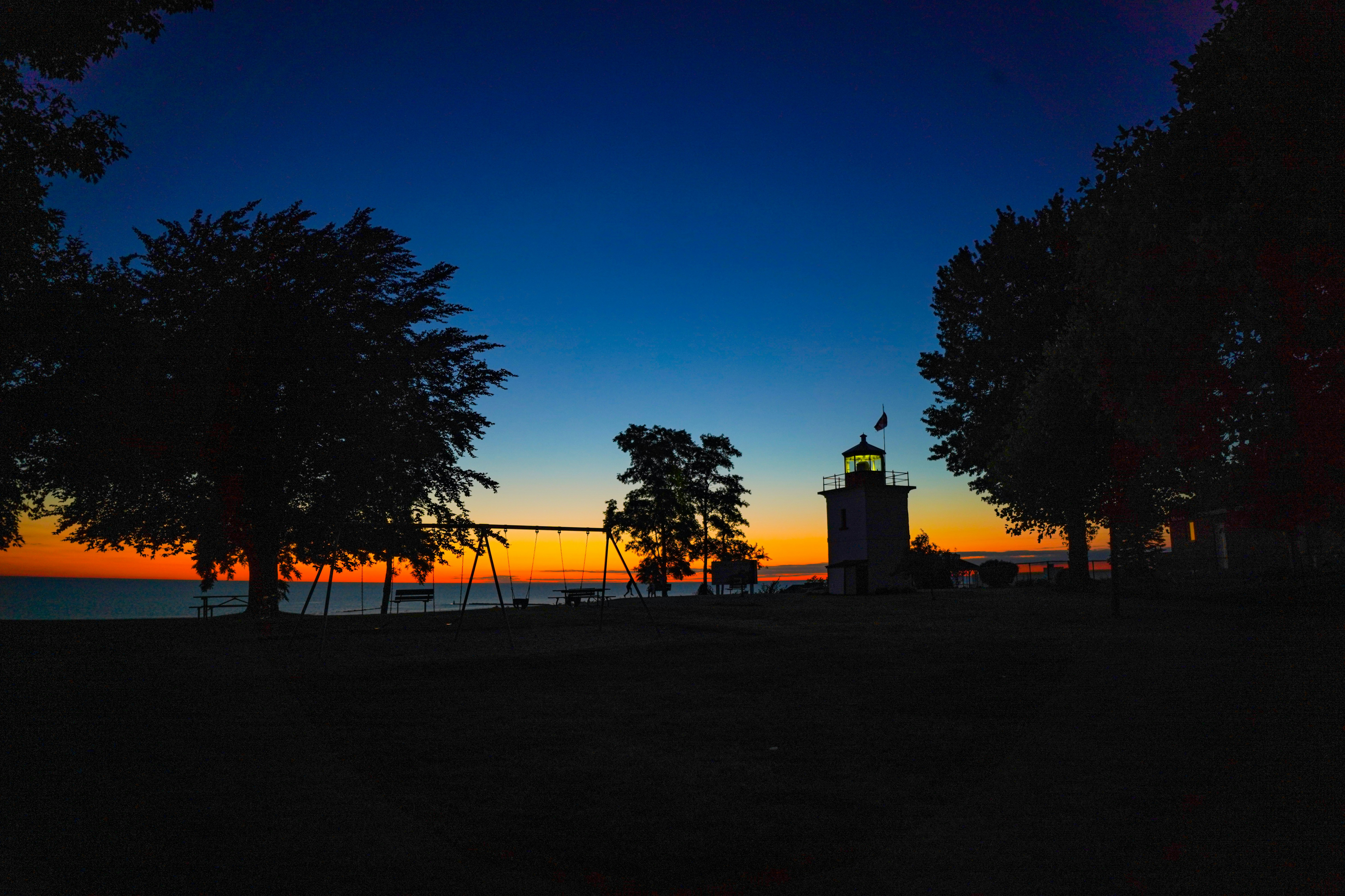 A building with a tower and trees by it at sunset photo – Free Nature ...