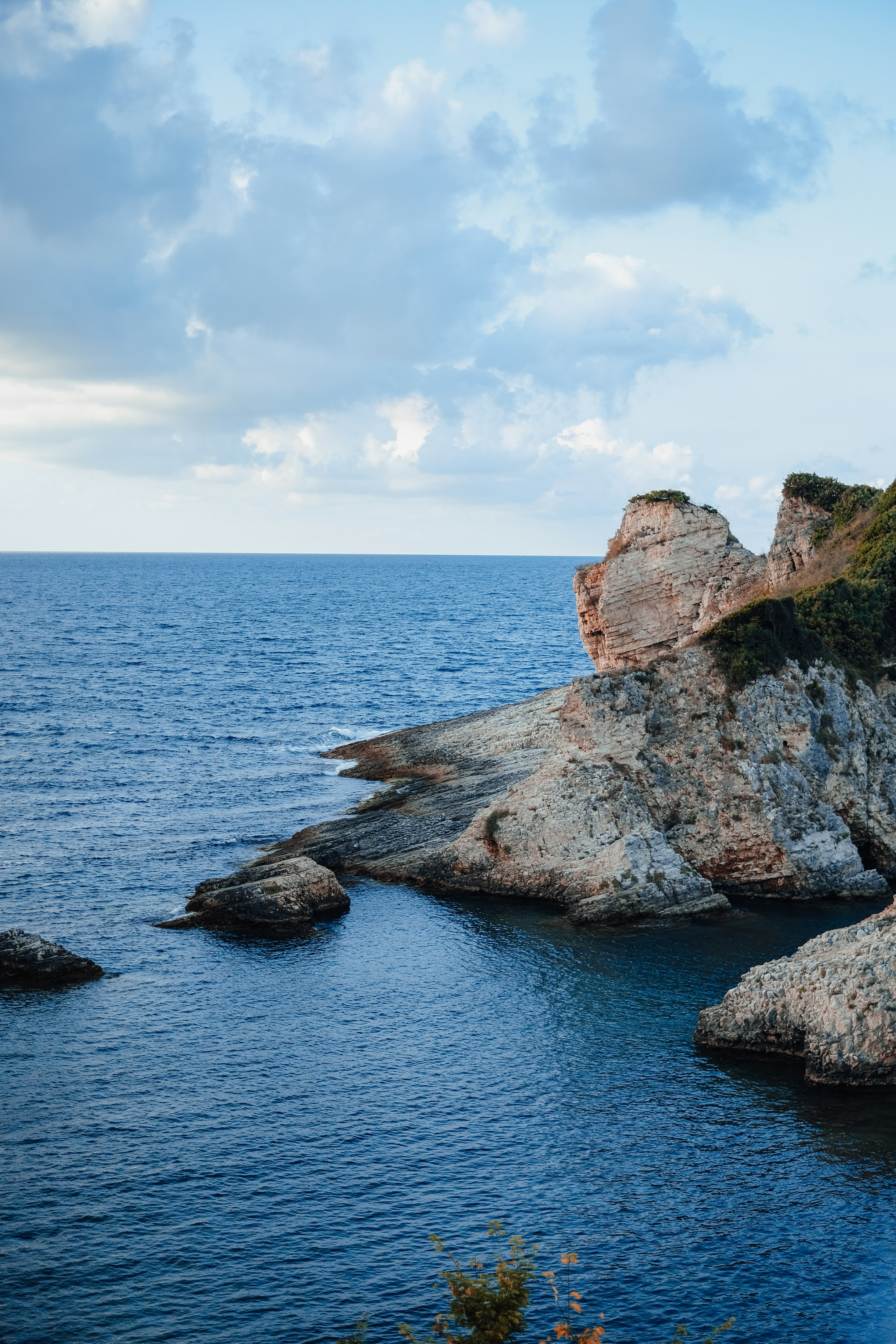 A rocky cliff next to the water photo – Free Promontory Image on Unsplash