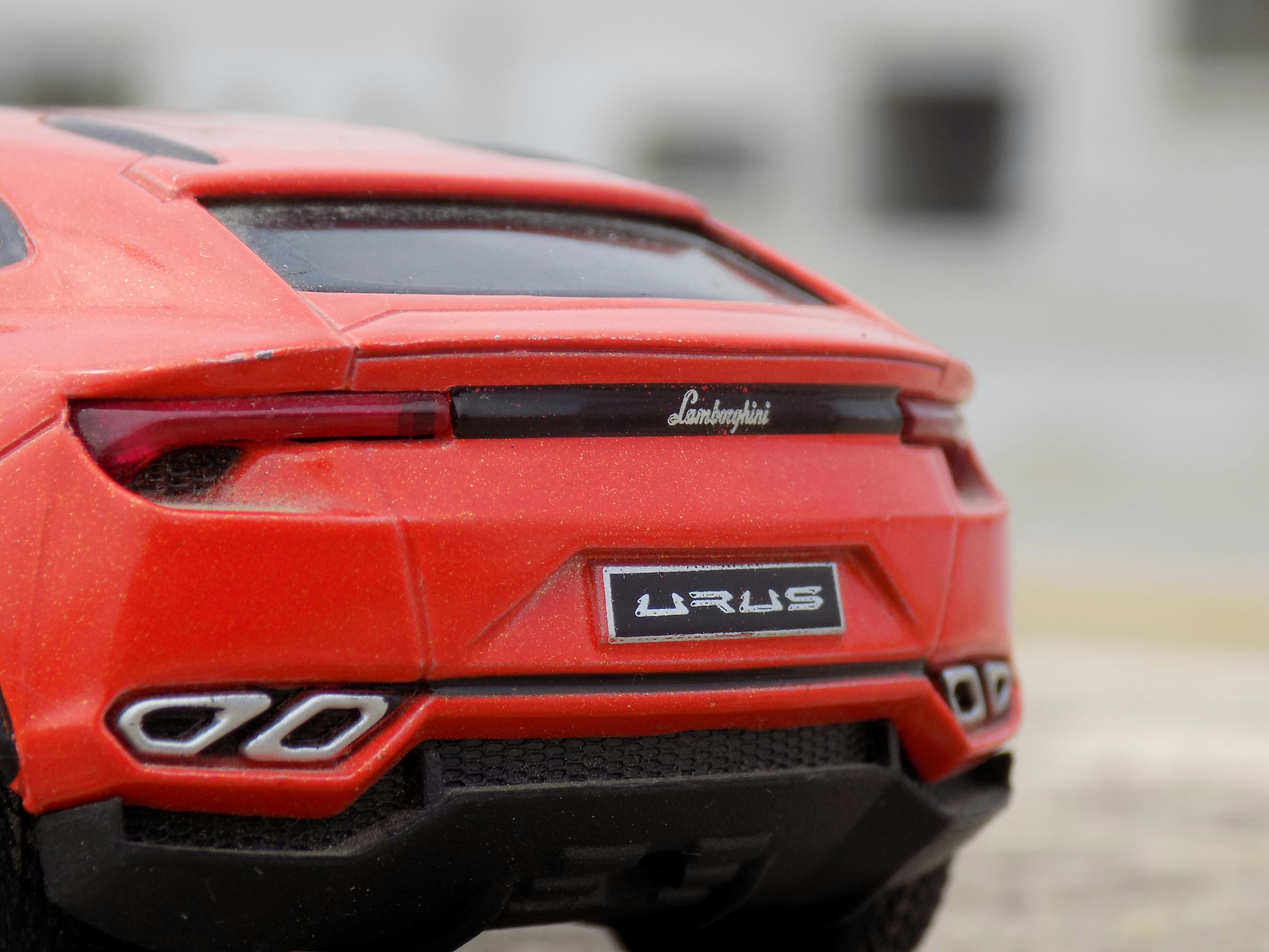 Close-up of a red toy car's rear, highlighting detailed taillights and branding.