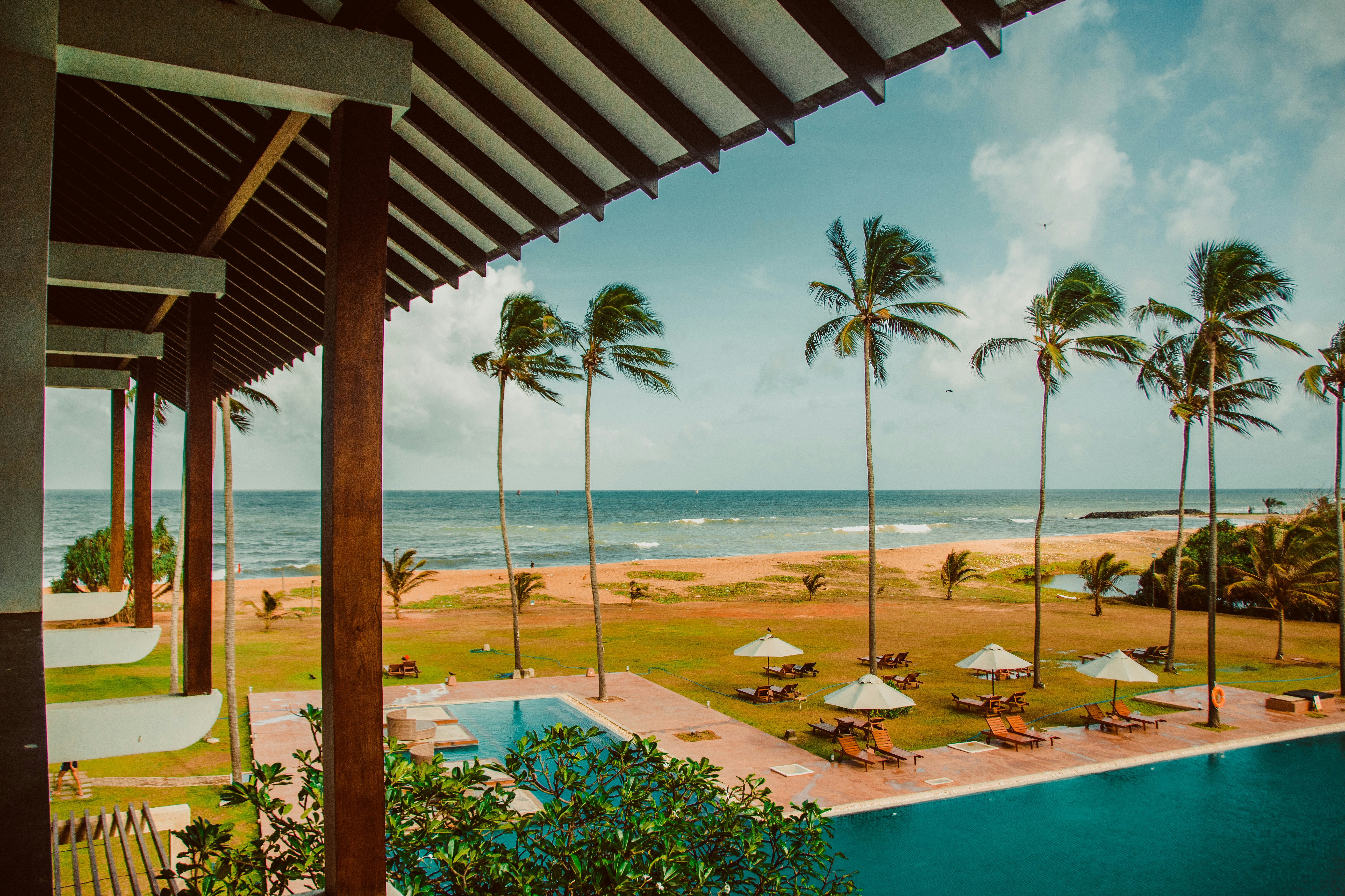 A pool with palm trees and a beach photo – Free Hotel Image on Unsplash