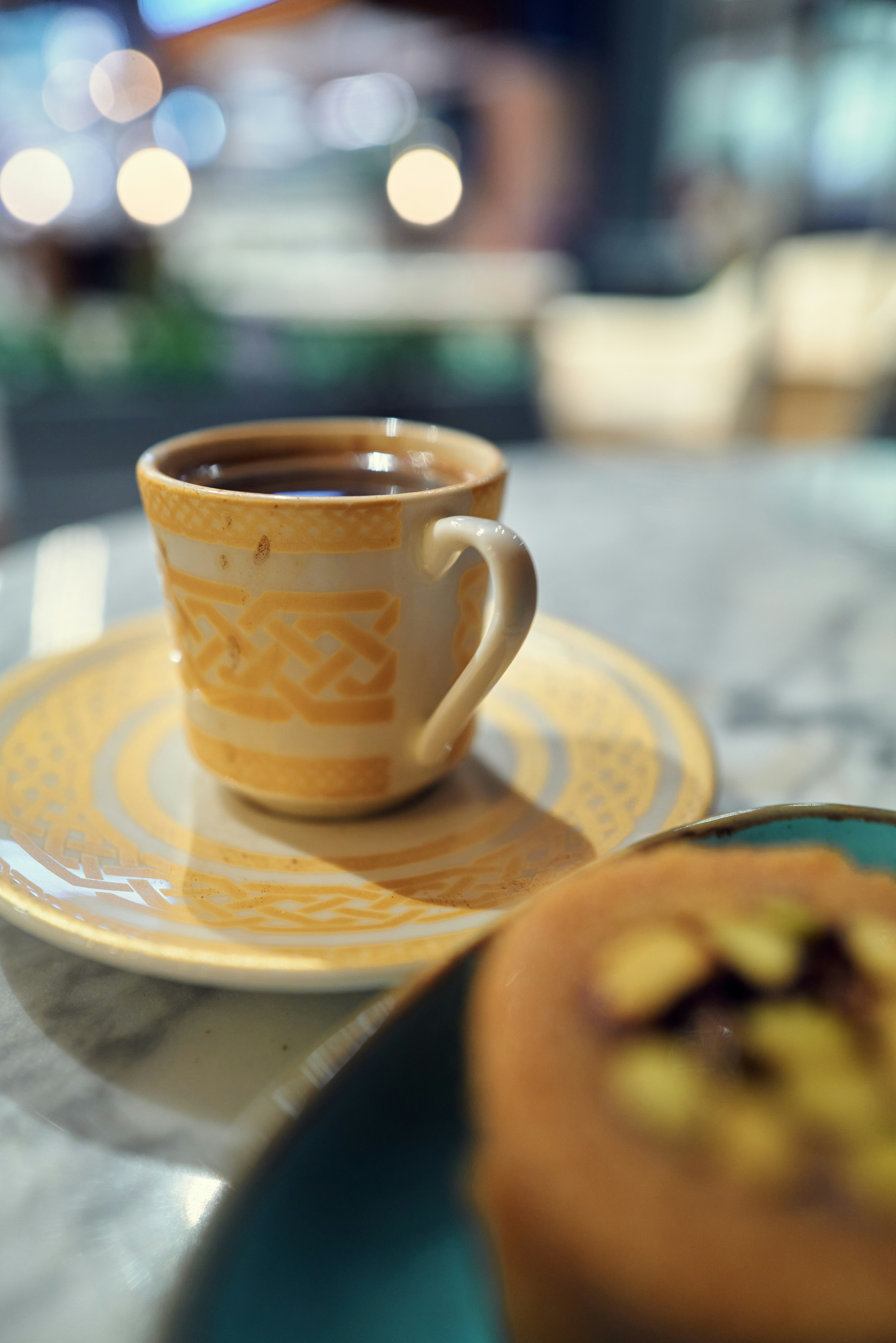 Cafe Ritual: A Coffee Cup Close-Up on a Blurred Bistro