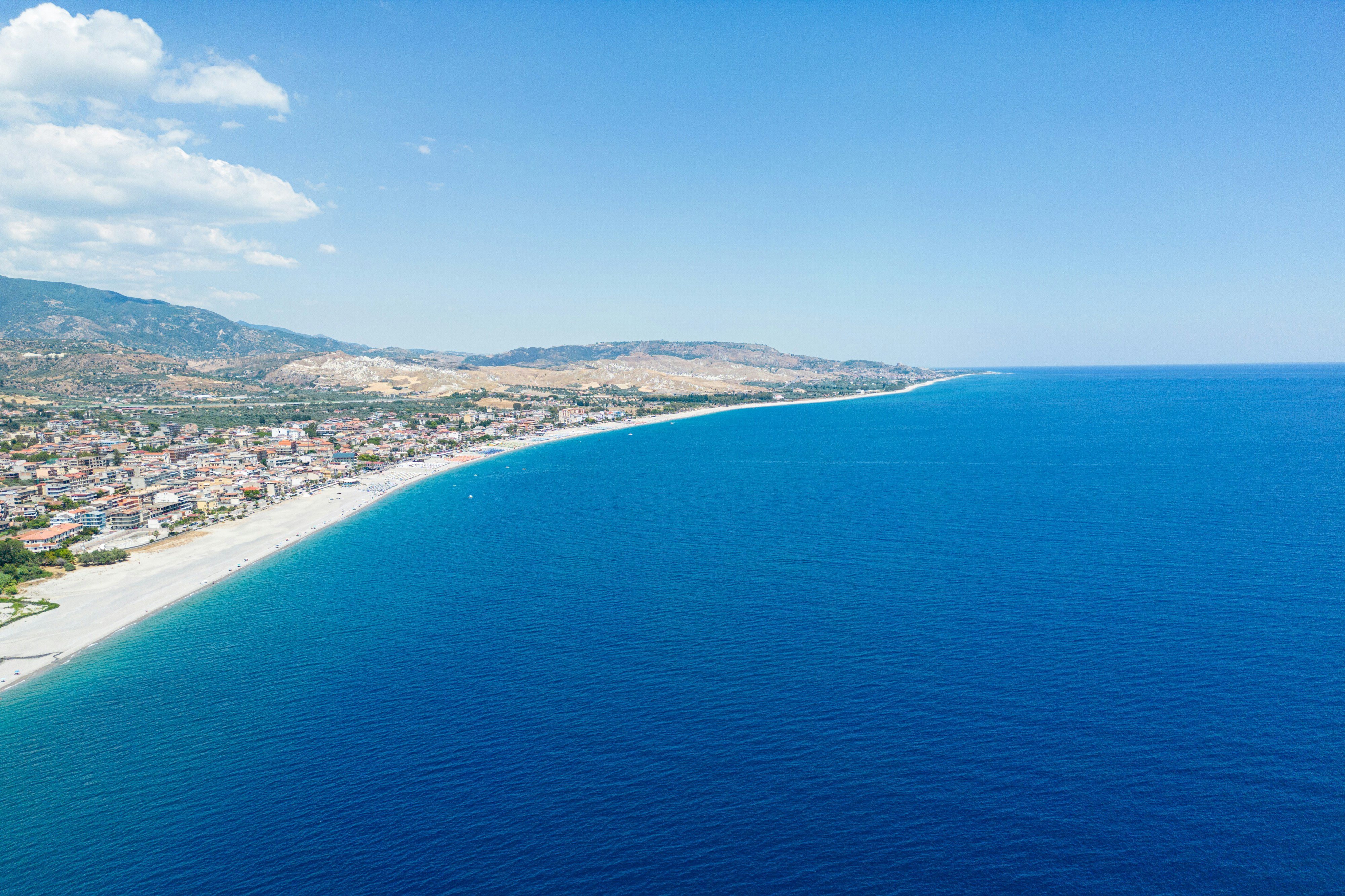 Expansive coastline meeting the deep blue sea under a clear sky.