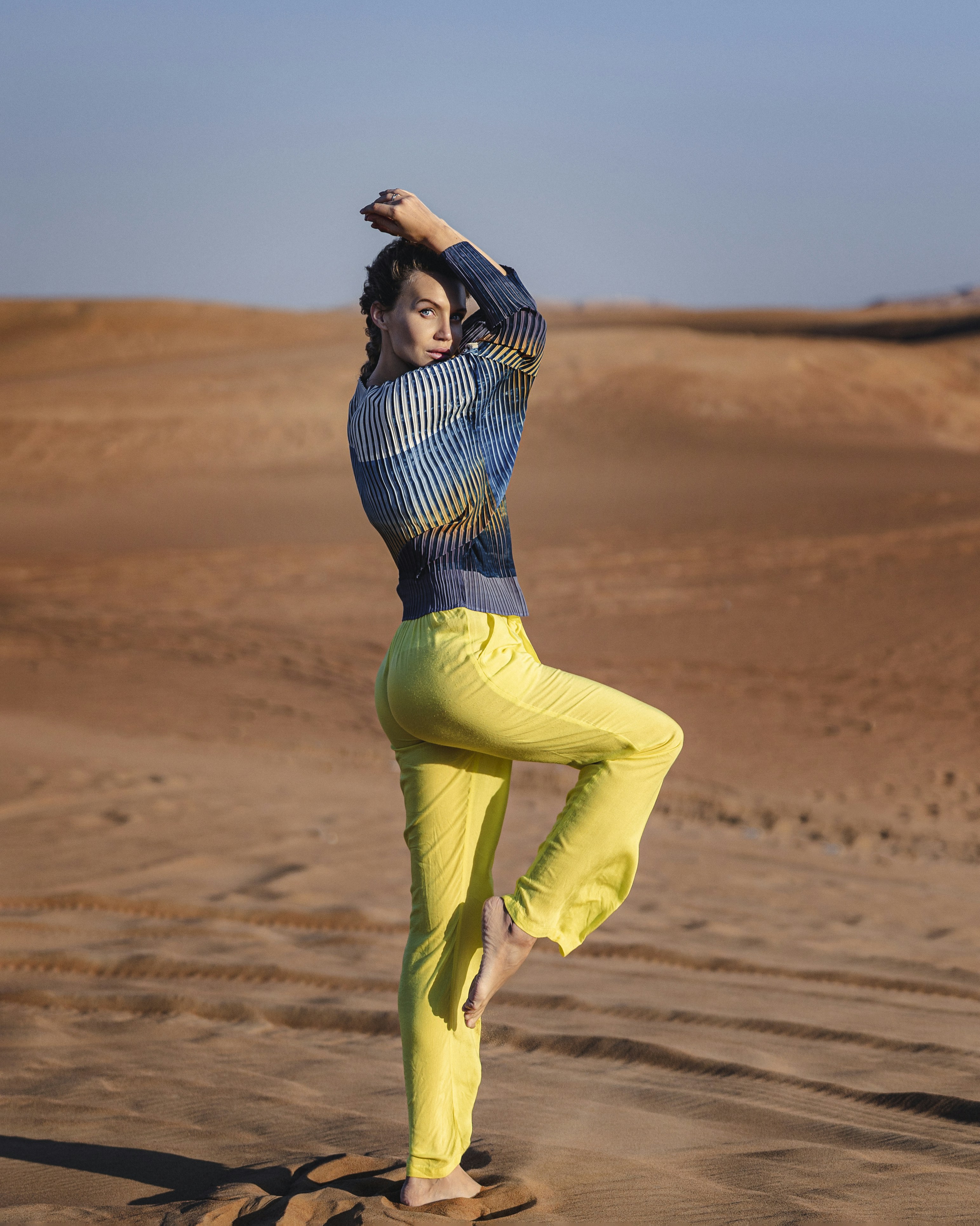 a person in a blue shirt and yellow pants jumping in the air