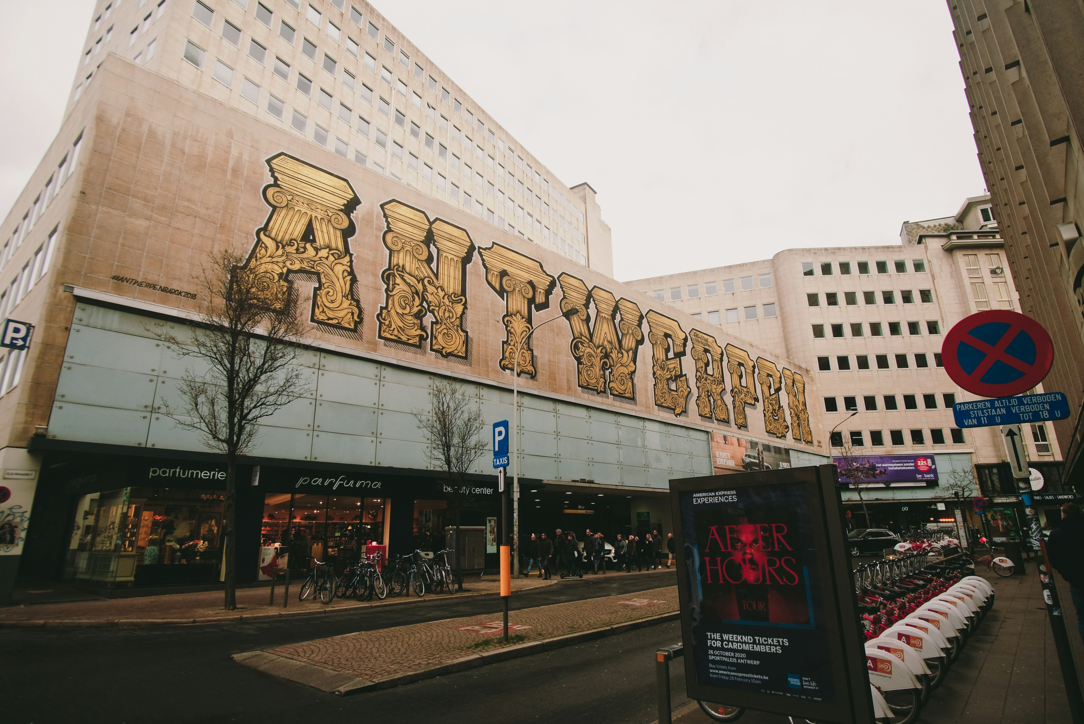 Vibrant mural spelling 'ANTWERP' on a city building, showcasing urban art and architecture. The scene captures the lively essence of city life.