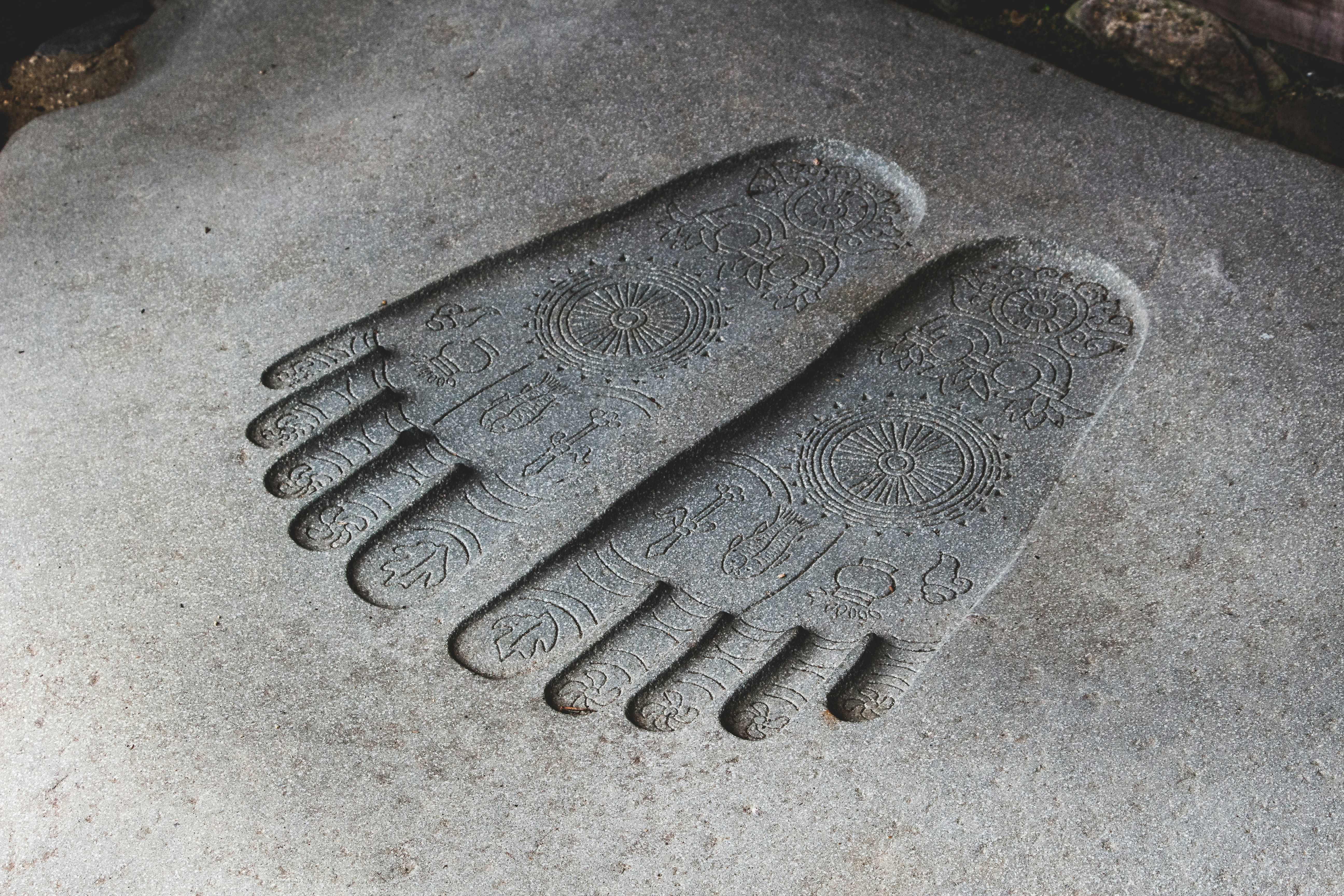 Carved Sandal Imprints: Time-Worn Pattern in Stone