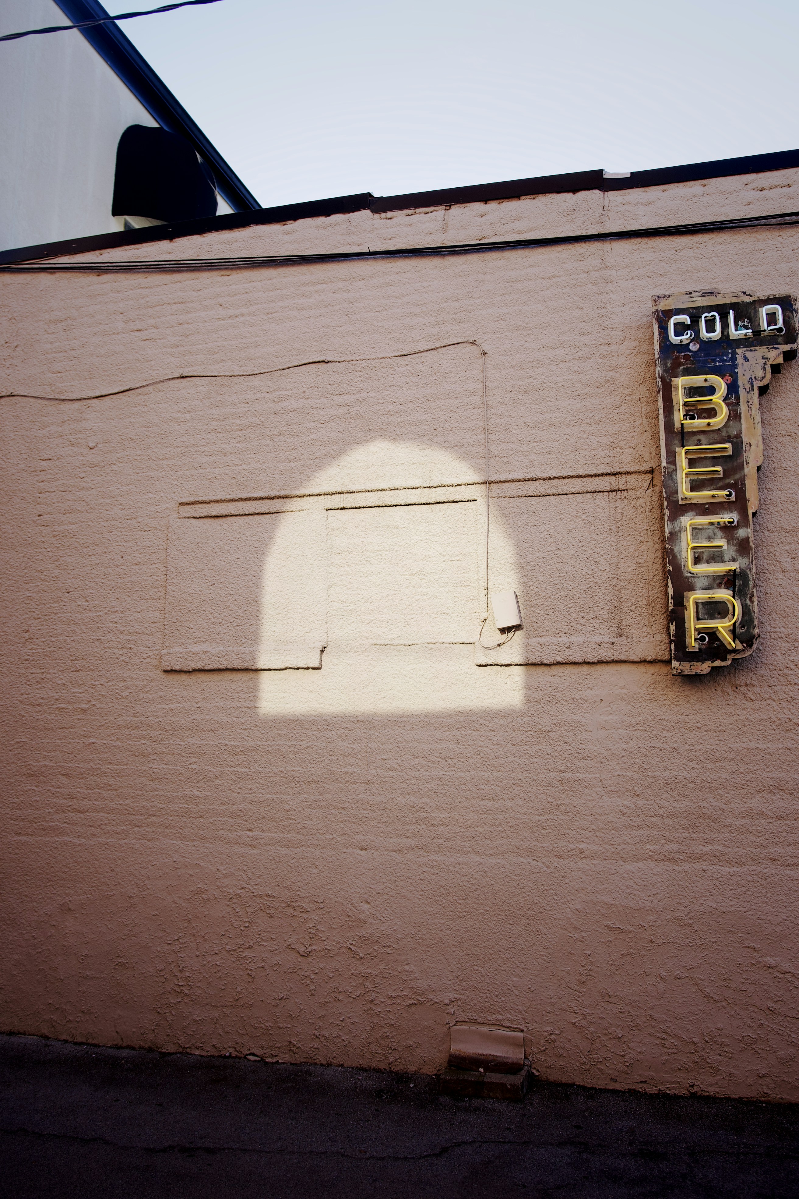 Sunlit Circle and Neon Edge: A Quiet Wall Portrait