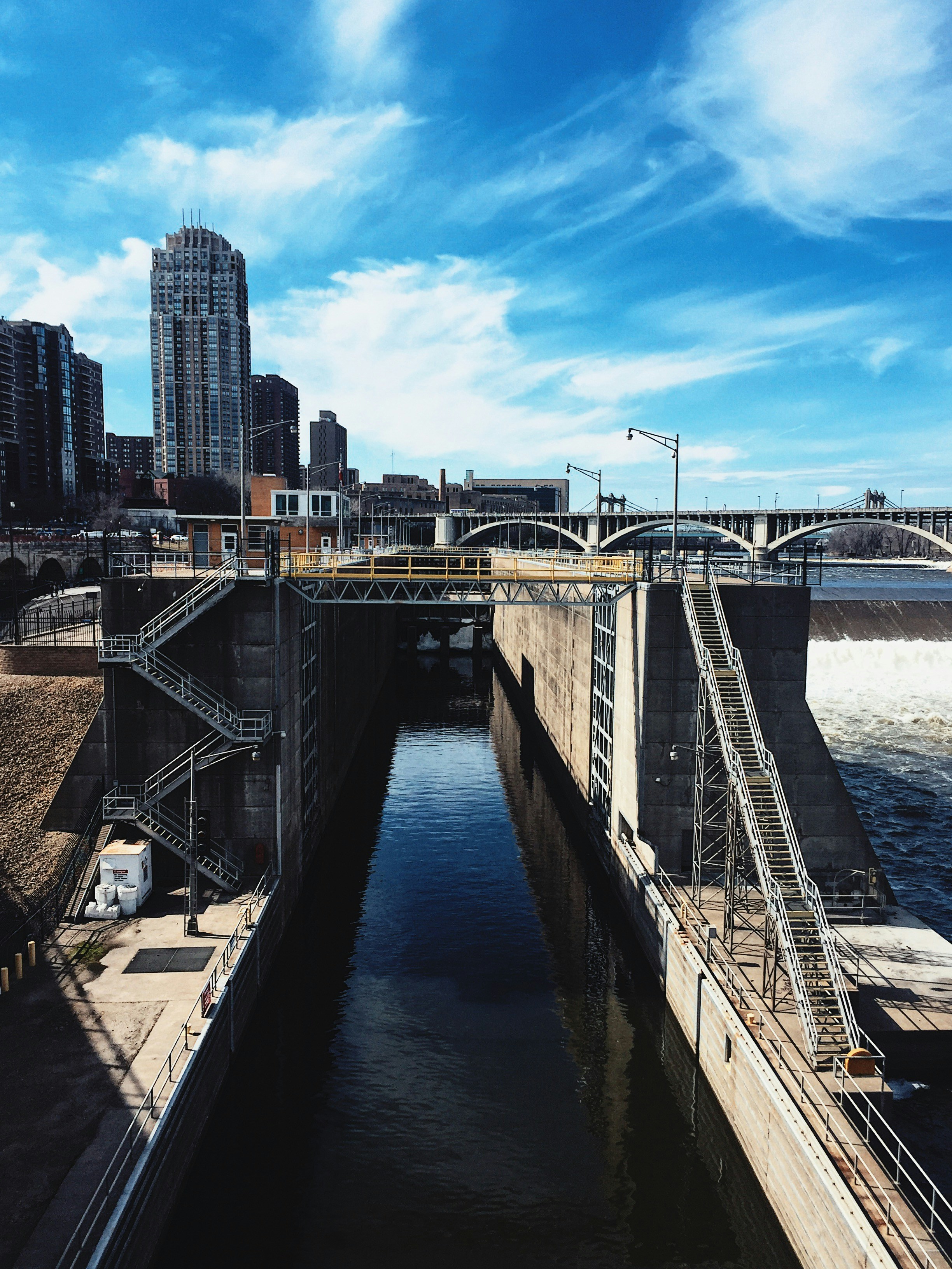 Echoes Along a City Lock: Steel Staircases Framing the Distant Skyline