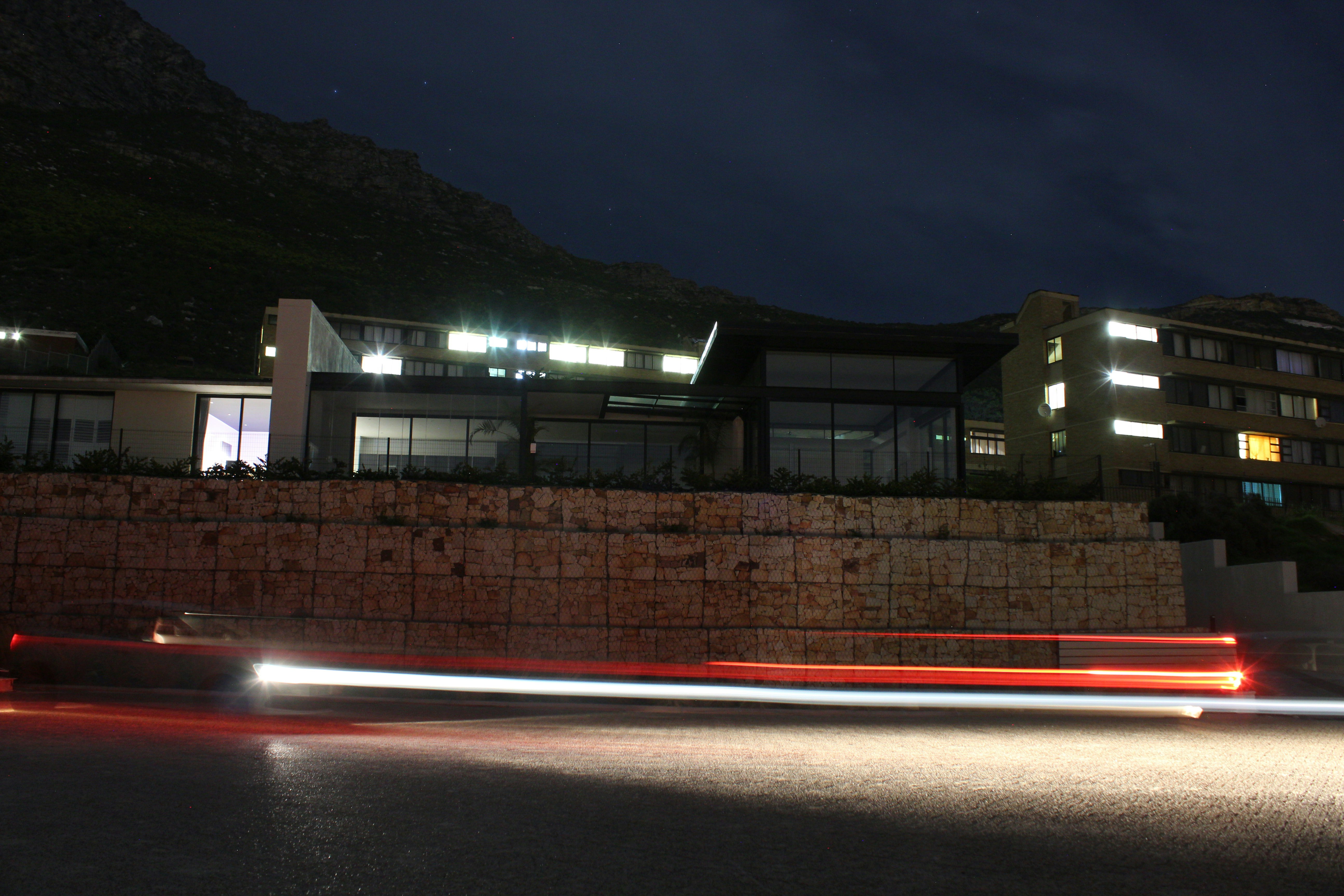 Midnight Red Traces Across a Modern Campus Facade