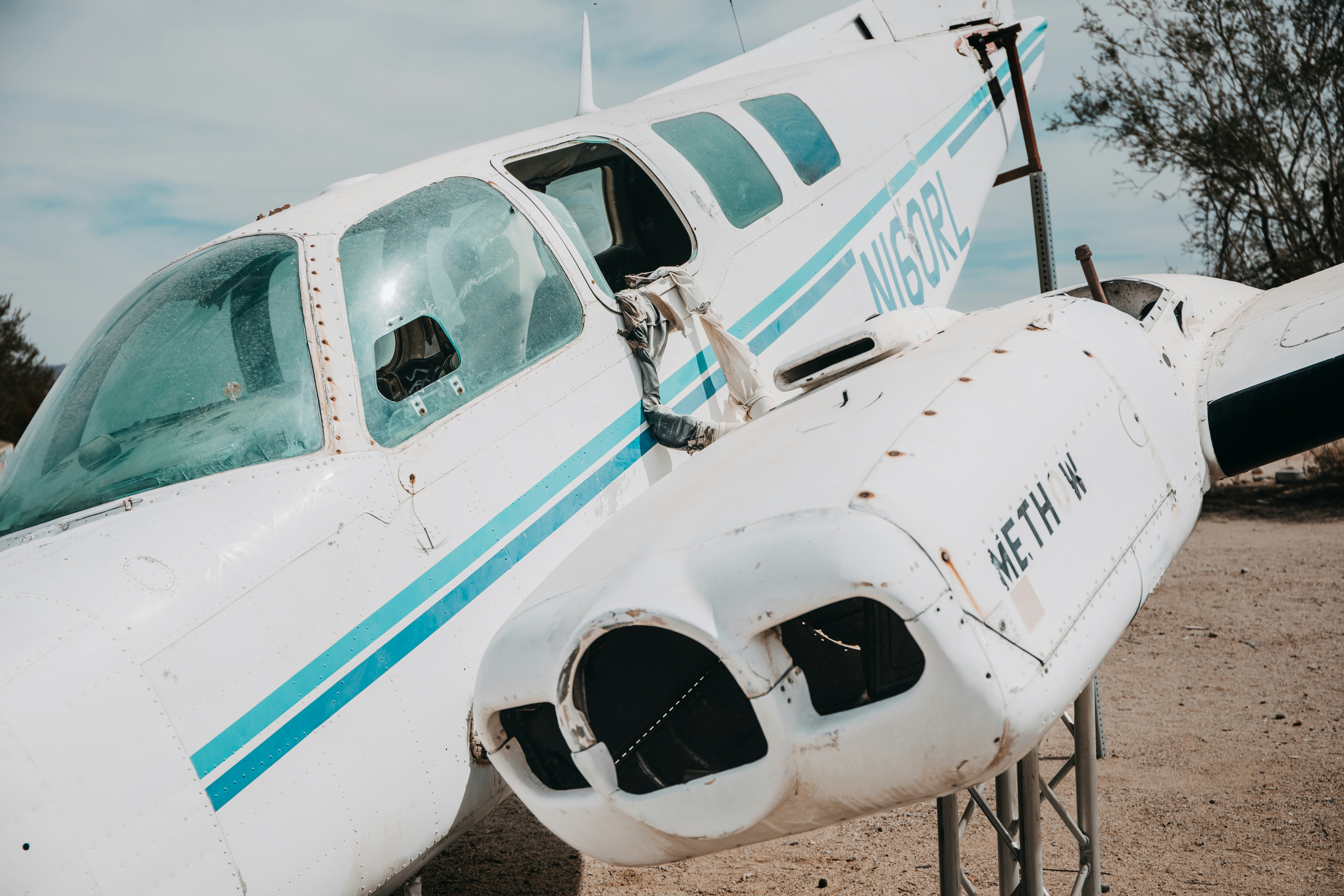 Sun-bleached Relic: Weathered Twin-Engine Light Aircraft in a Desert Scrapyard