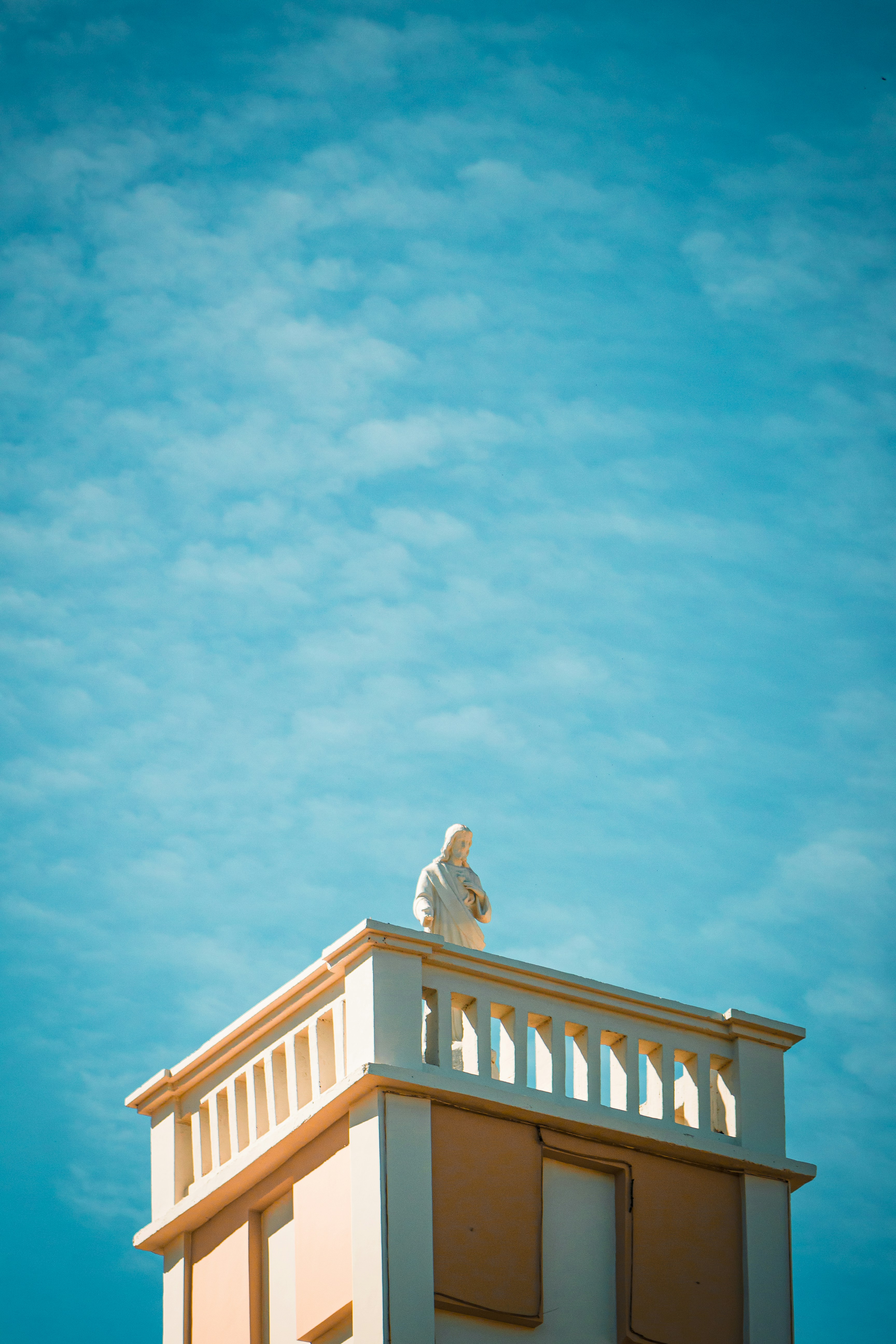 White Sentinel on a Peach Terrace Against a Vast Blue Sky