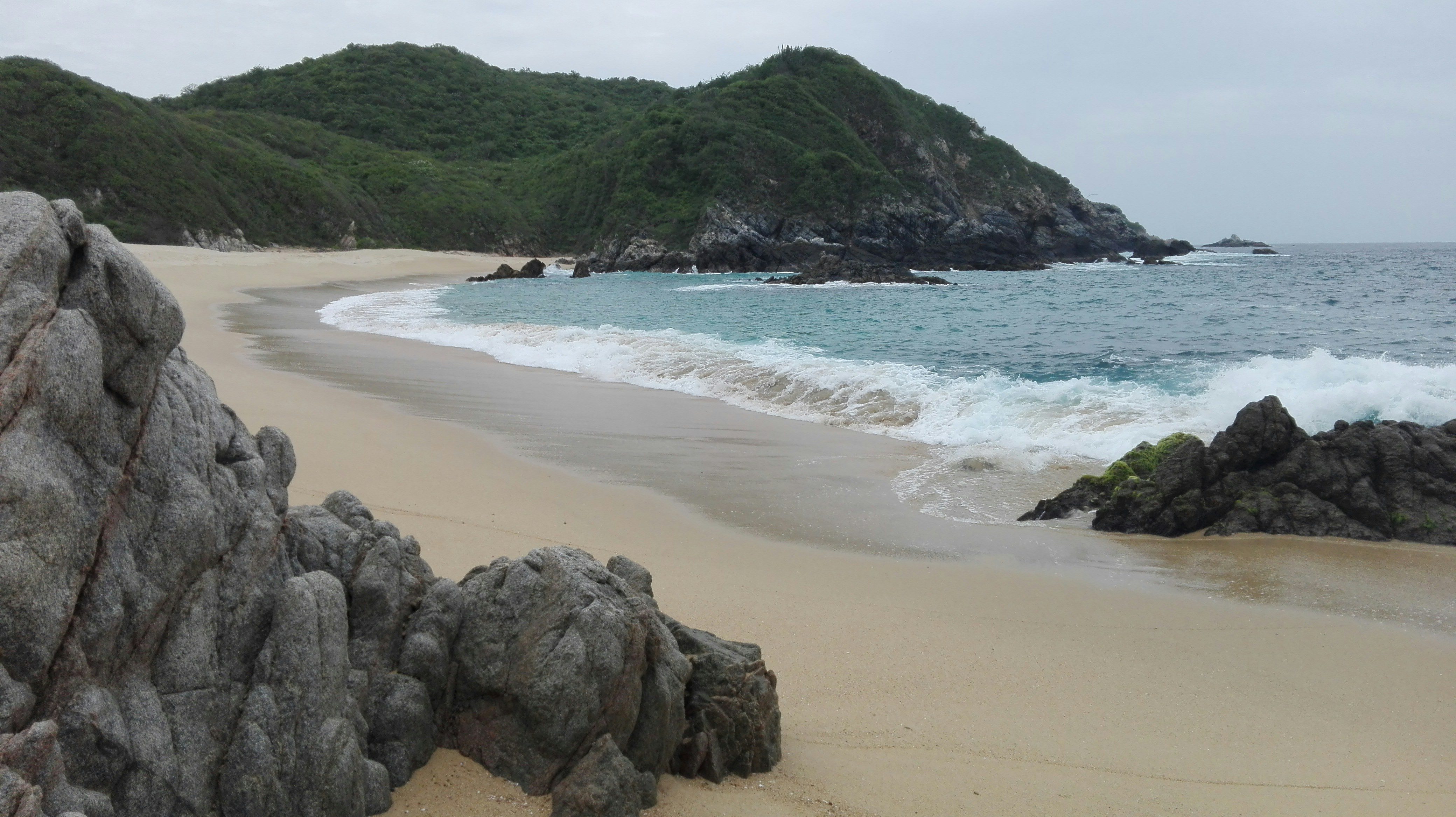 Una playa con rocas y una colina al fondo foto – Imagen de Mayto ...